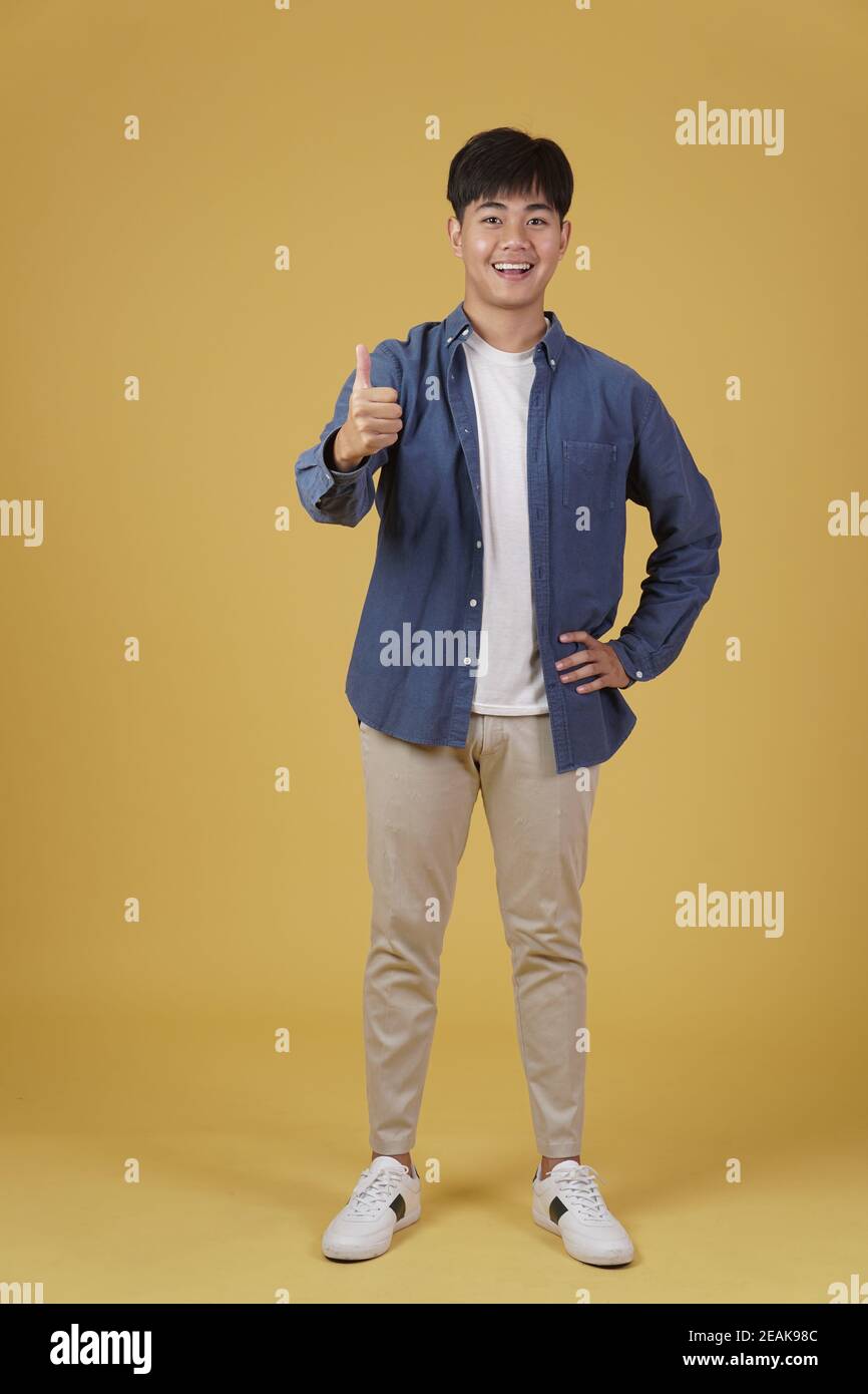 portrait of smiling positive young asian man dressed casually with ...