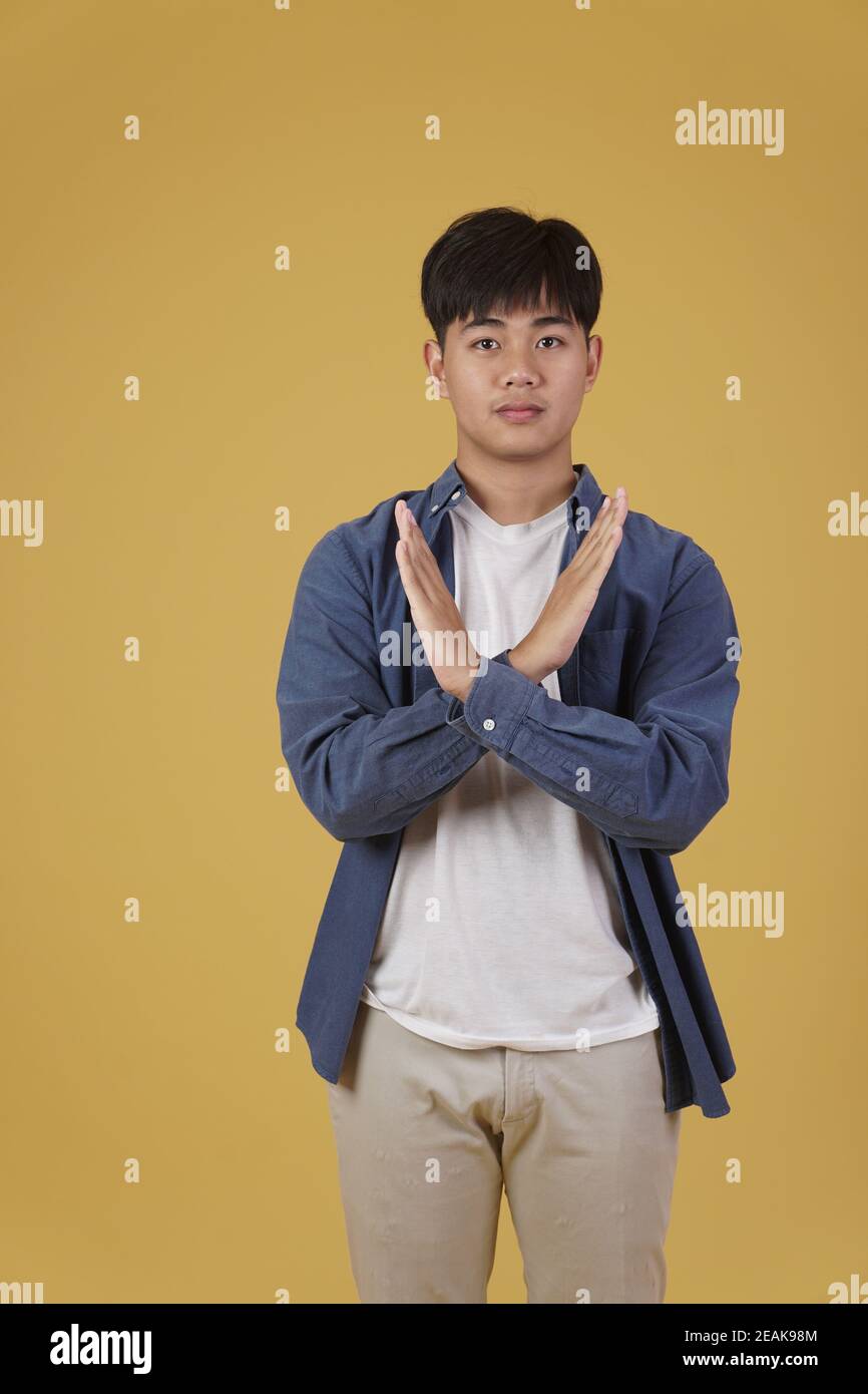 portrait of handsome young asian man dressed casually crossing arms in ...