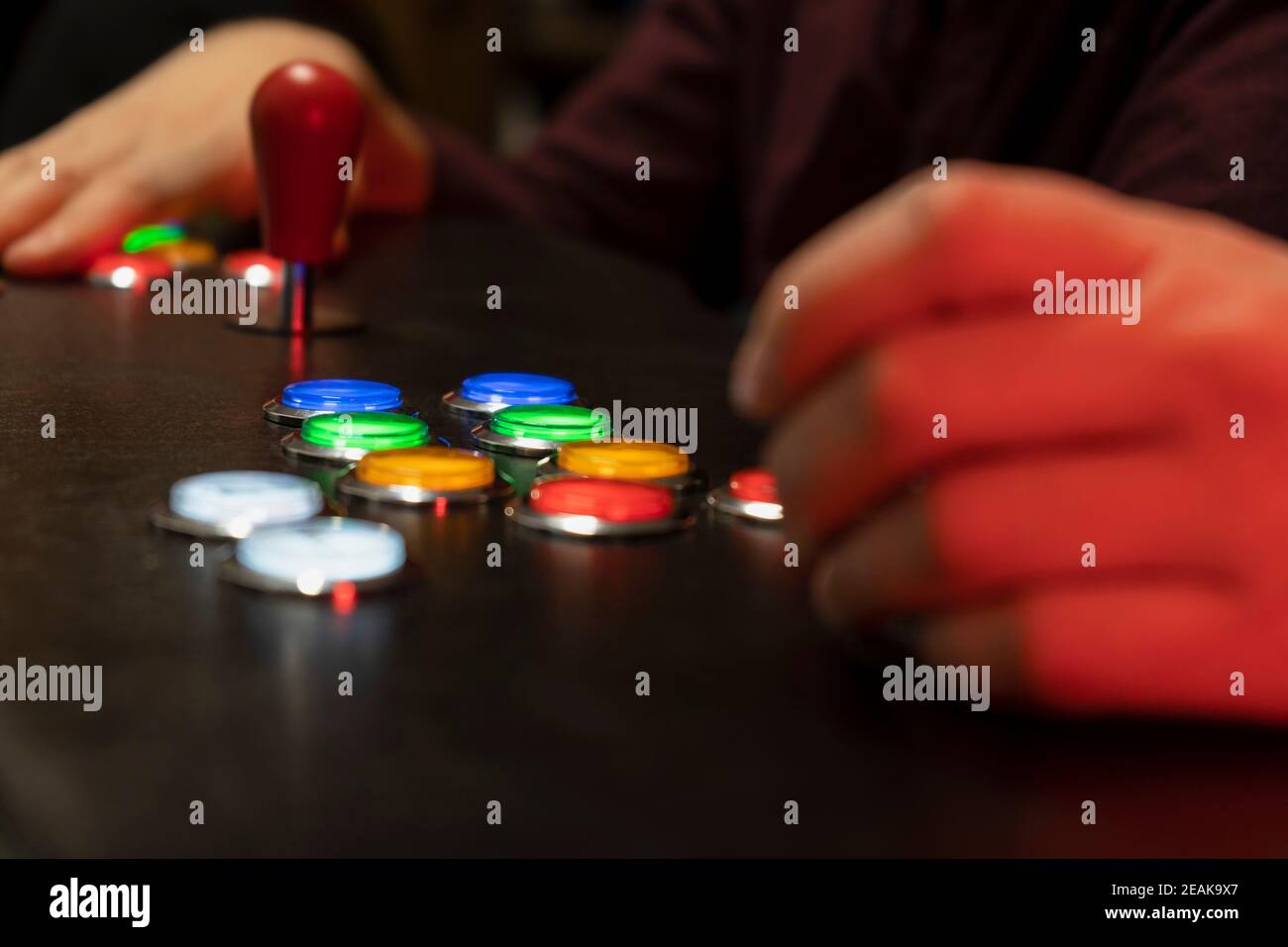 Closeup view of two people hands playing arcade vintage video games ...
