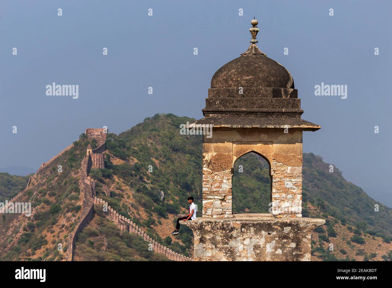 Young Boy sitting on watch tower of Amber fort with wall and ramparts ...
