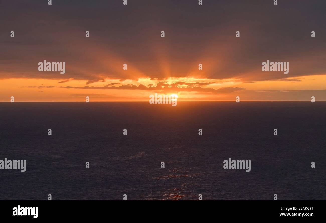 Beautiful sunset with red orange sun with rays going down to the ...