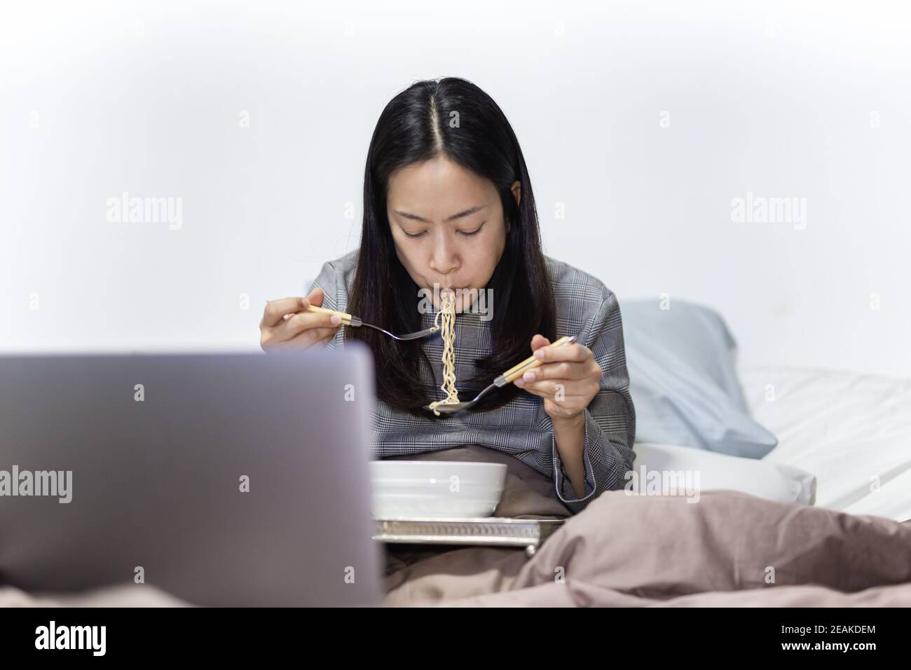 Asian businesswoman eating at computer hi-res stock photography and ...