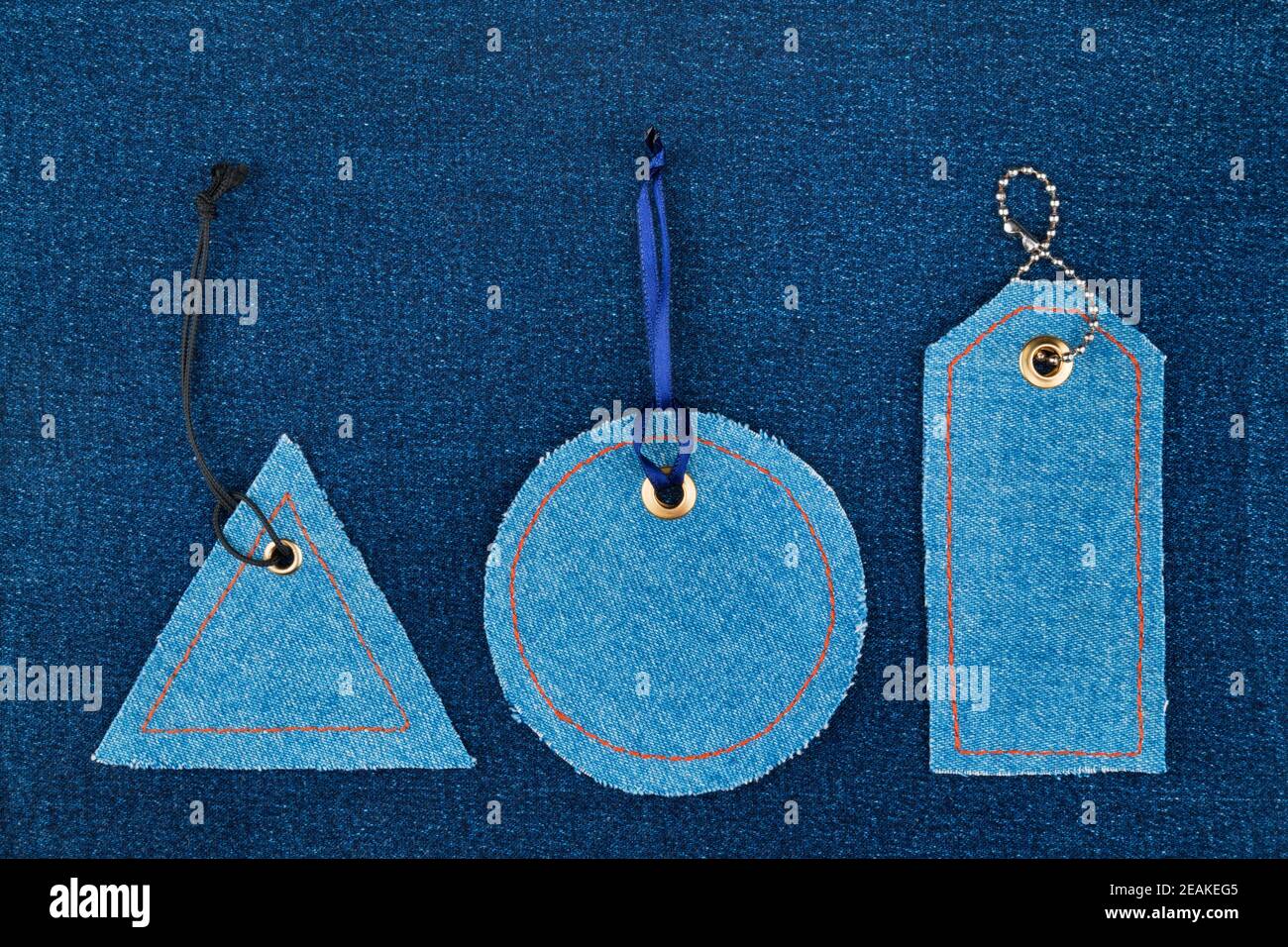 Collection of price tags made of denim lying on a dark denim. View from ...