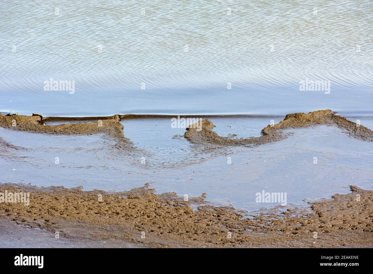 Abstract sand curves meeting water Stock Photo - Alamy