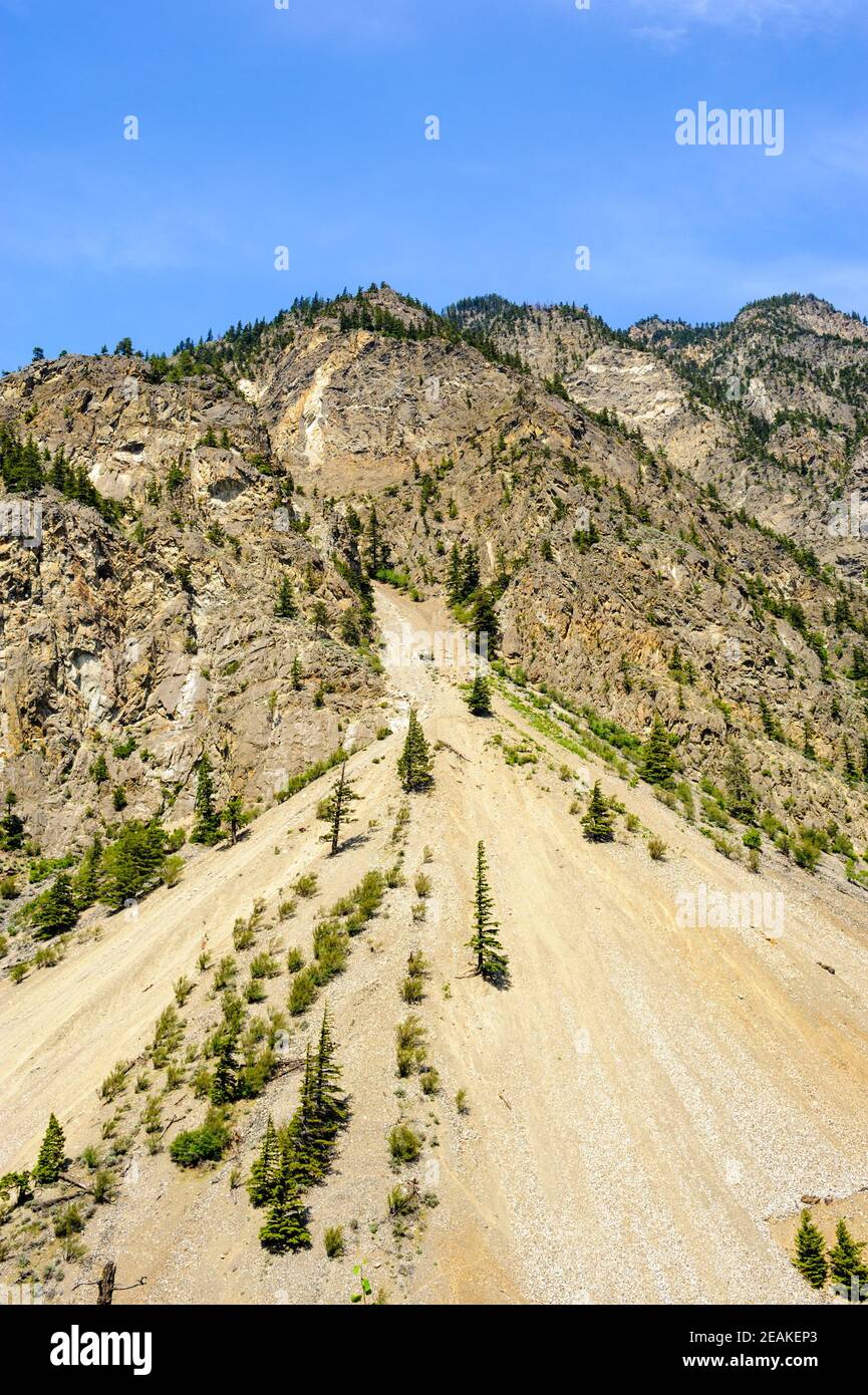 Sand and rocks spreading out under mountain range Stock Photo - Alamy