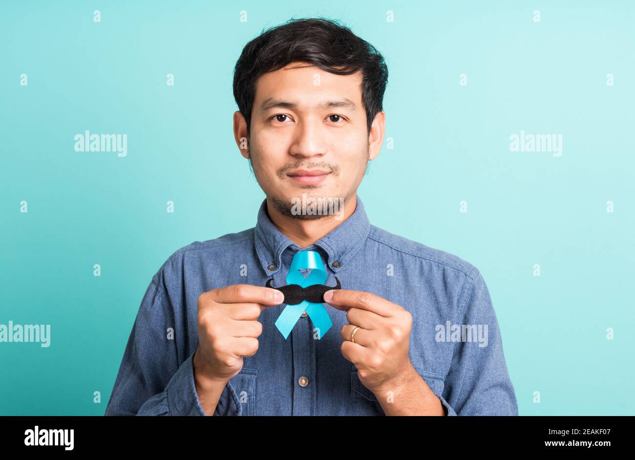 handsome man posing he holding a light blue ribbon and mustache Stock ...