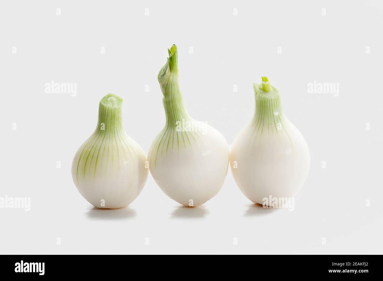 Detail of three onions on white background Stock Photo - Alamy