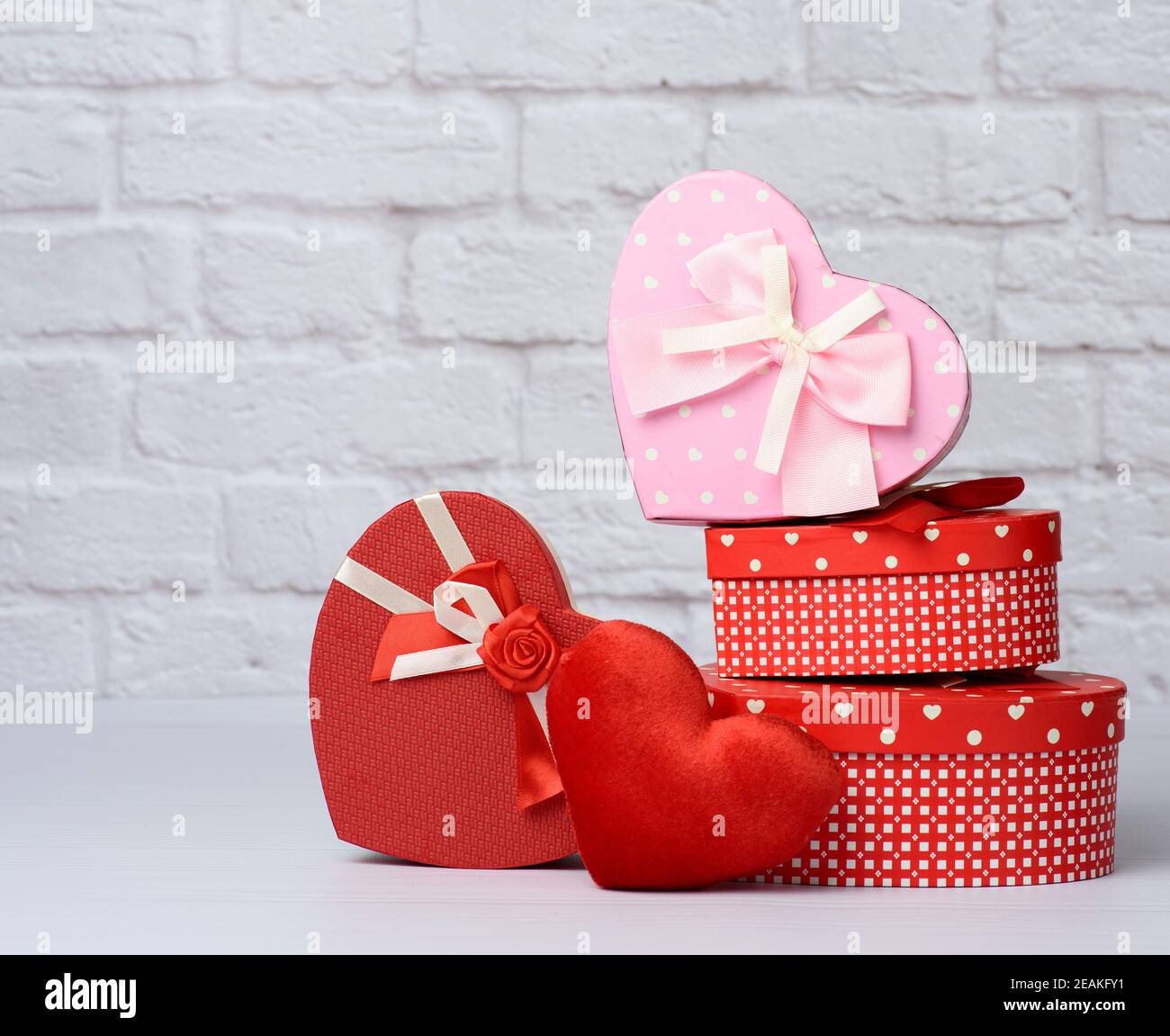 stack of various red boxes with gifts on white brick background Stock ...