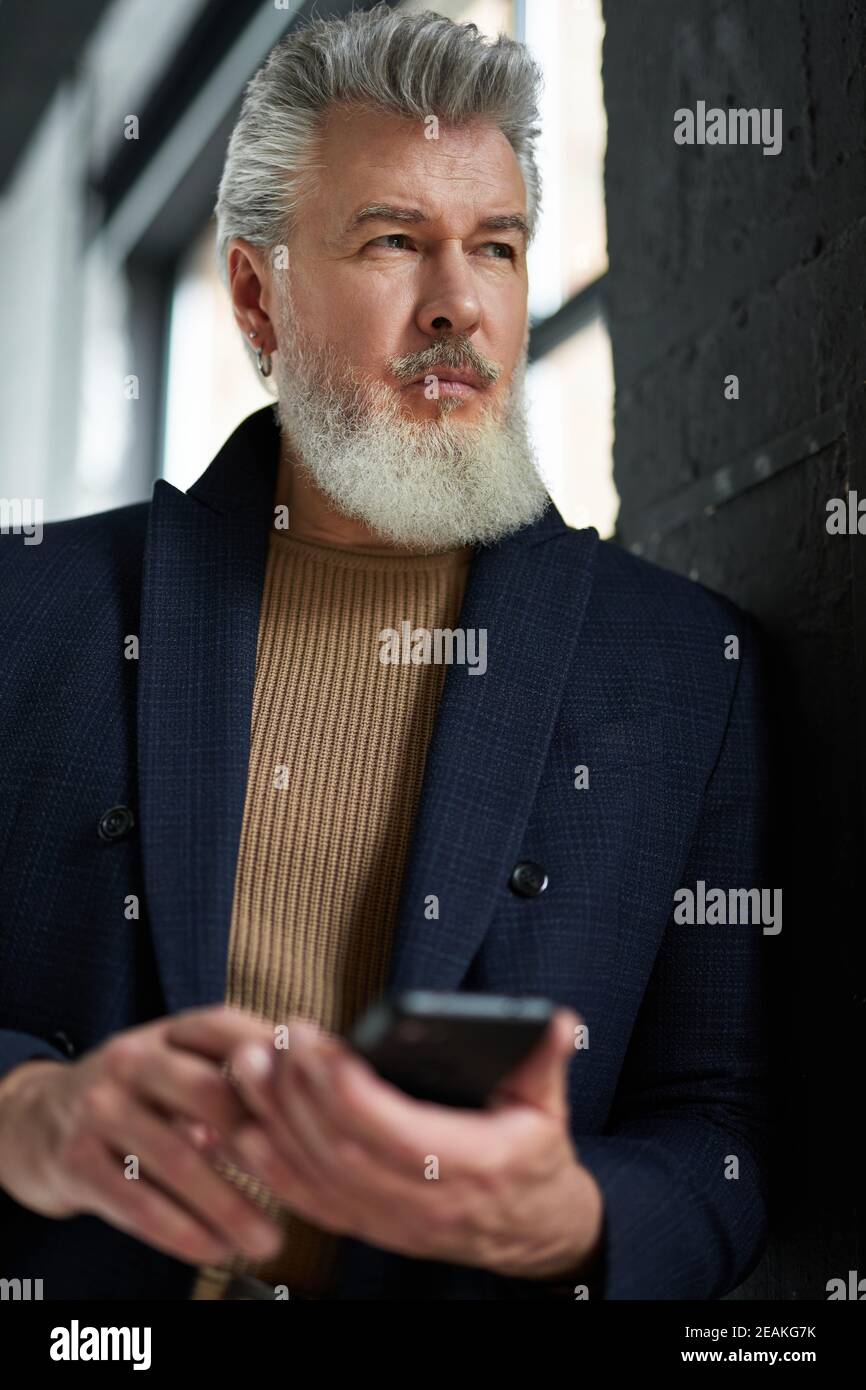 Portrait of serious grey haired middle aged man in business casual wear ...