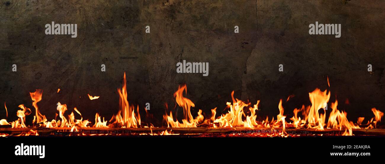 Fire flames in front of dark concrete wall Stock Photo - Alamy