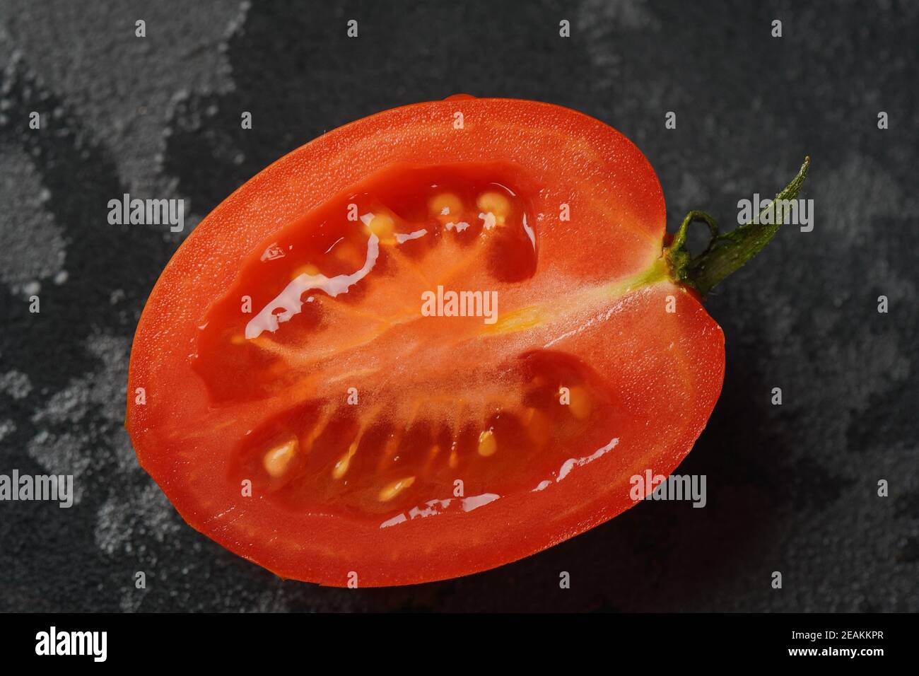 Piece of cut fresh tomato over dark background Stock Photo - Alamy