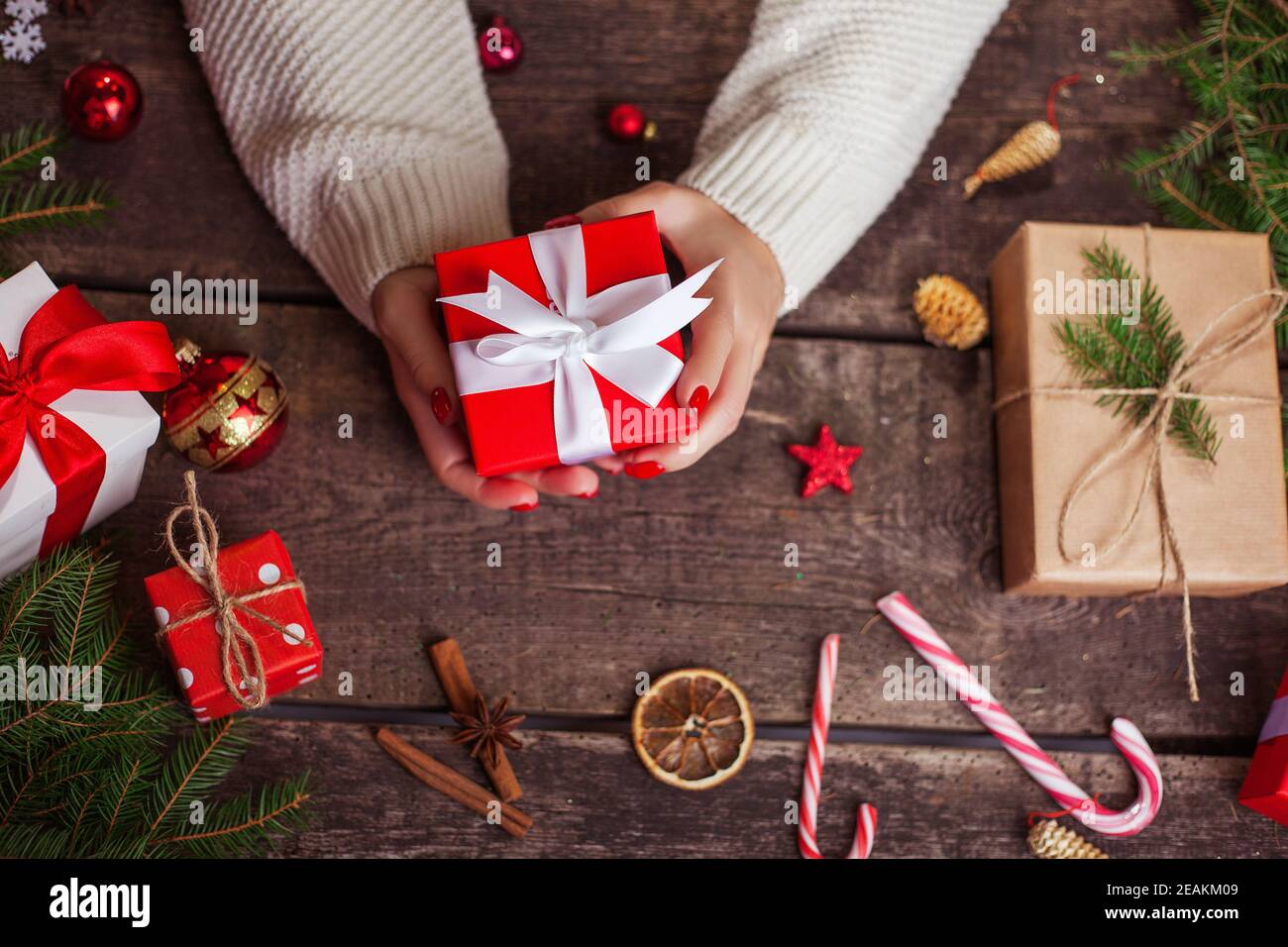 Woman holding a gift box in a gesture of giving Stock Photo - Alamy