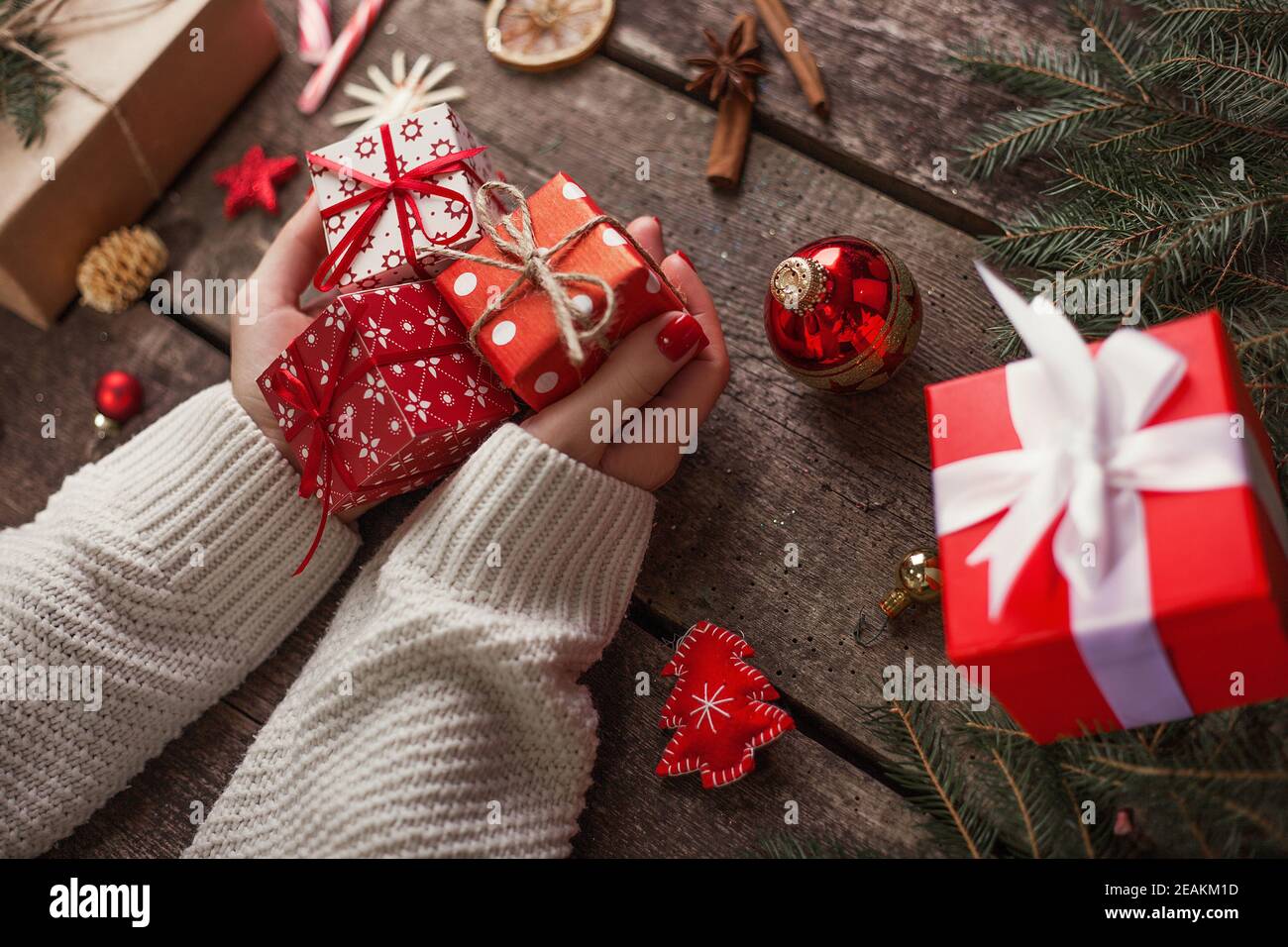 Woman holding a gift box in a gesture of giving Stock Photo - Alamy