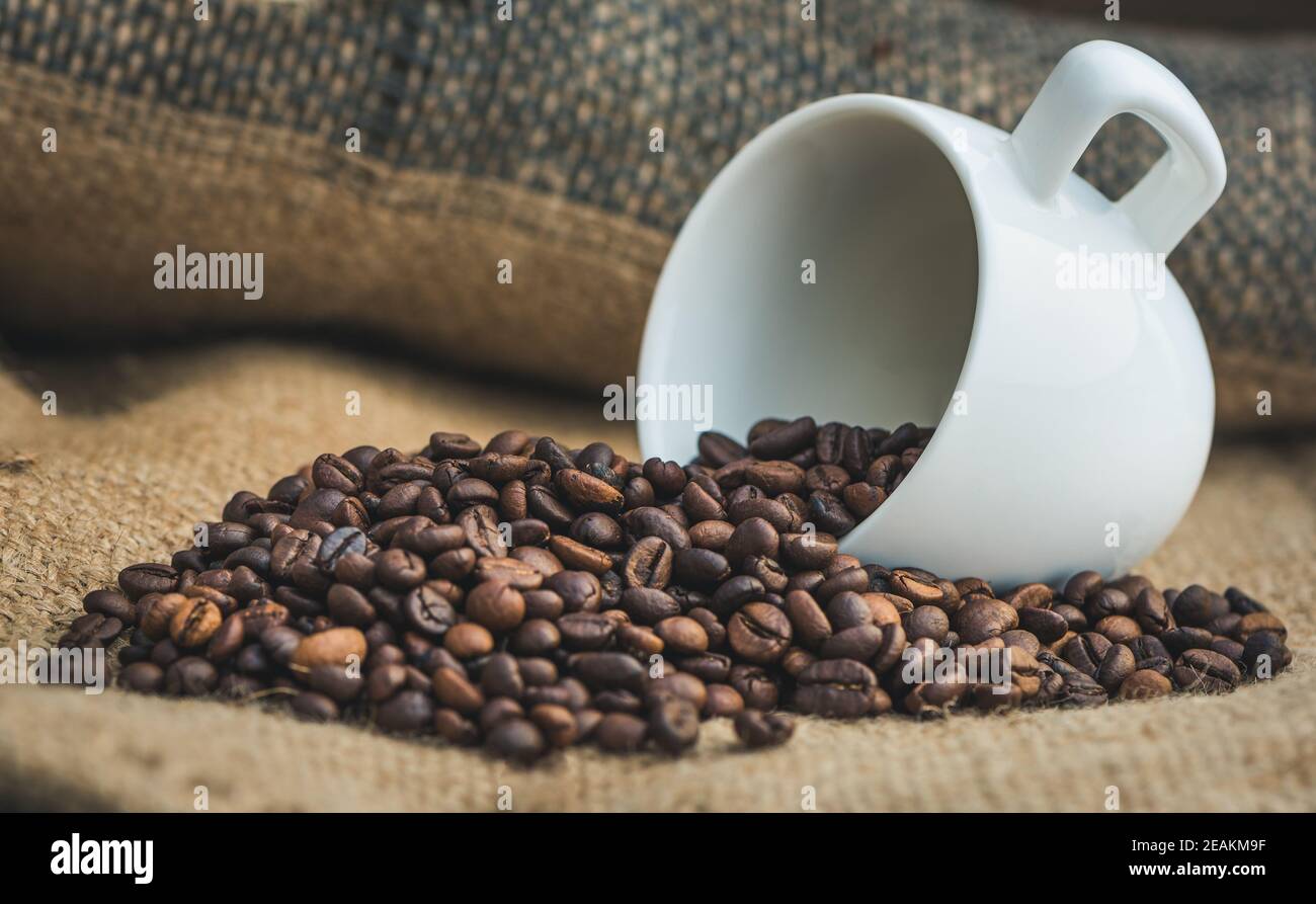 Coffee Beans Spilled out of Cup Stock Photo - Alamy