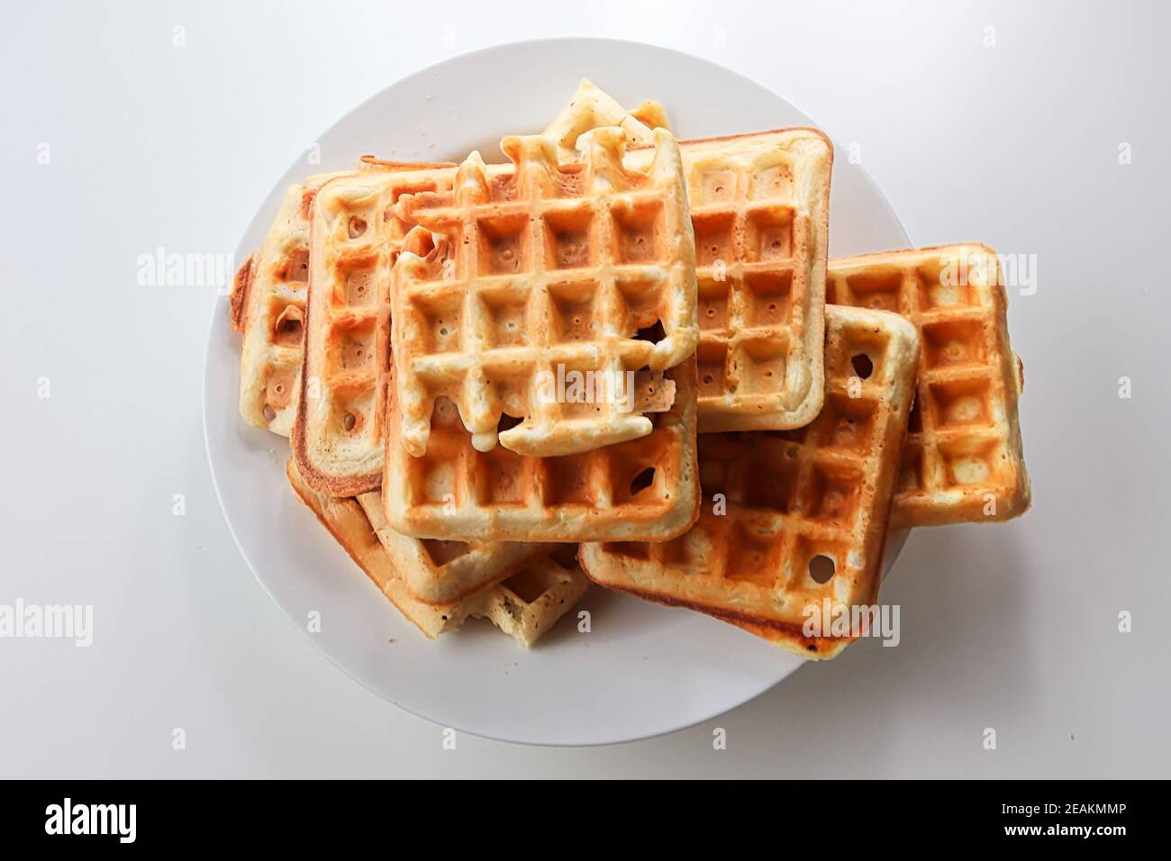 Plain waffles on a while plate against a white background Stock Photo ...