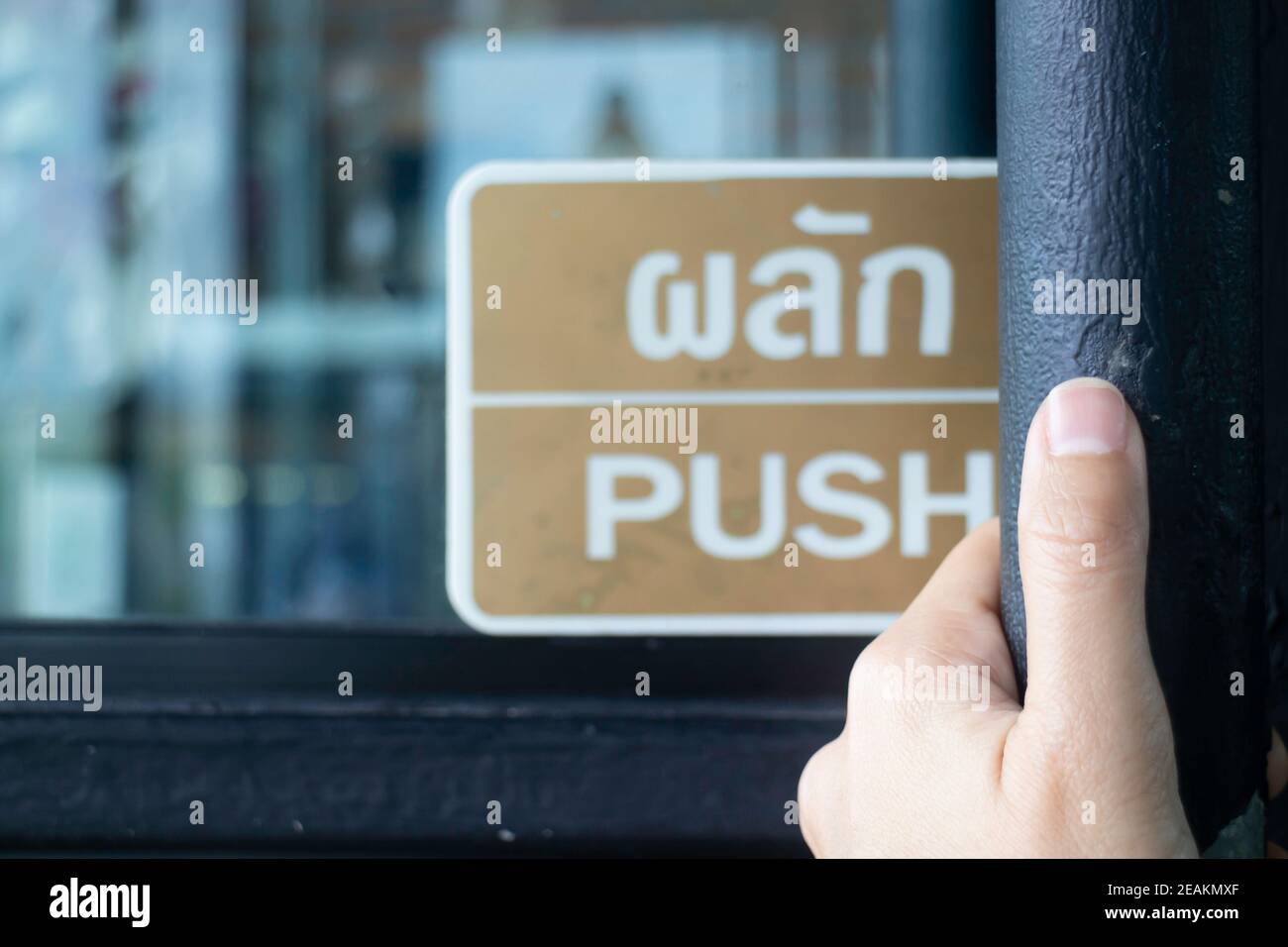 Hand on opening into store door Stock Photo - Alamy