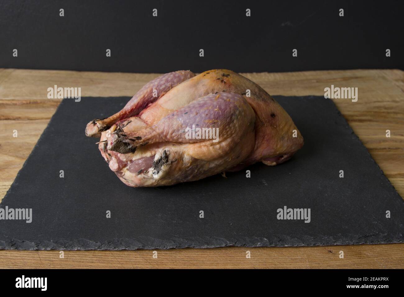 raw grouse photographed on a wooden cutting board with a black ...