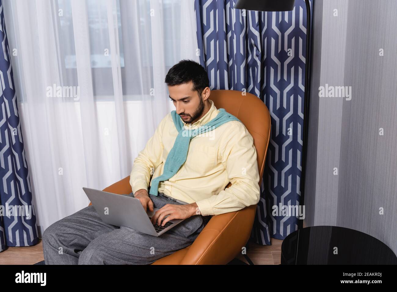 Young muslim freelancer using laptop in hotel room Stock Photo - Alamy