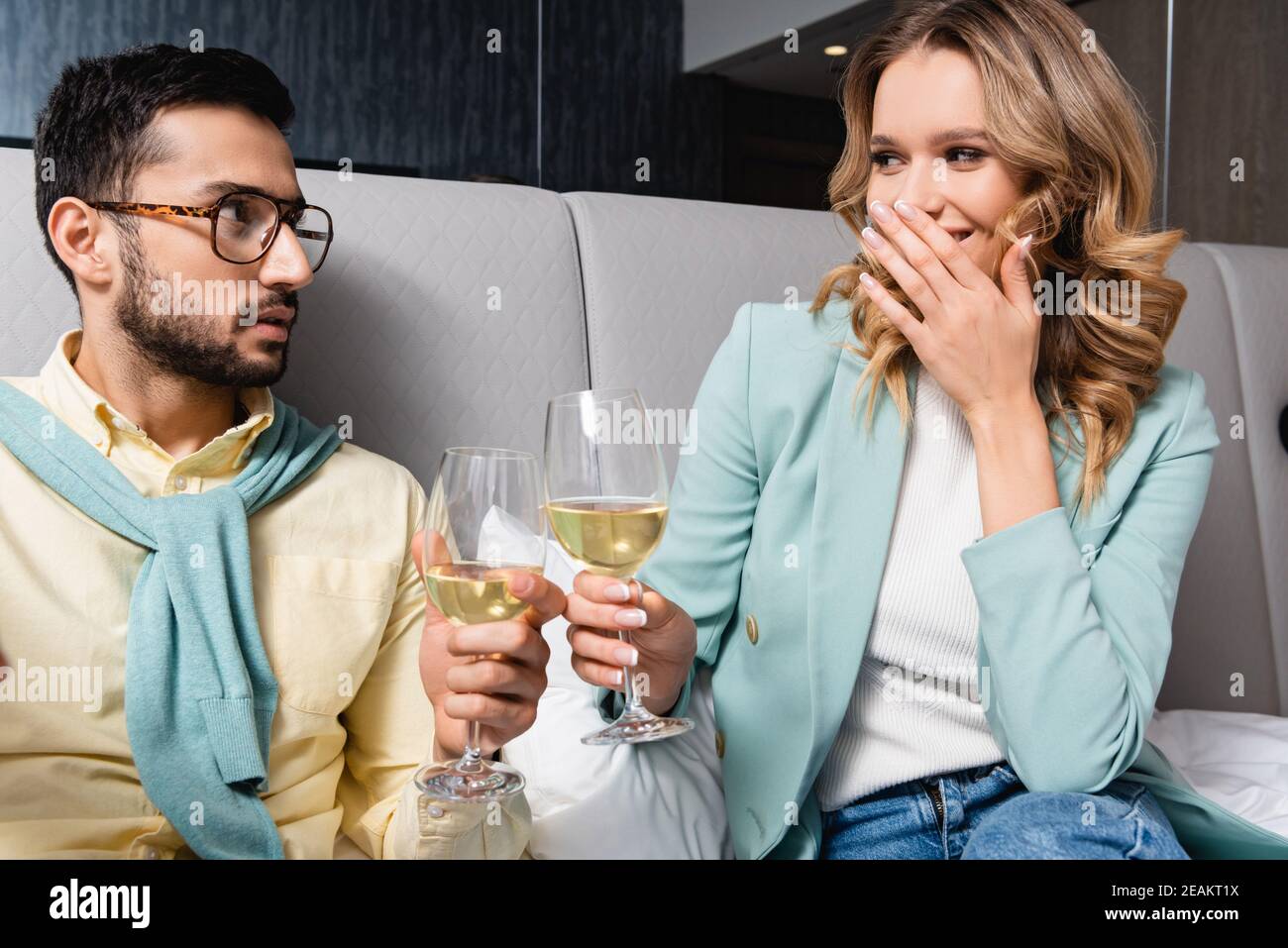 Cheerful woman toasting wine with Muslim boyfriend in hotel Stock Photo ...
