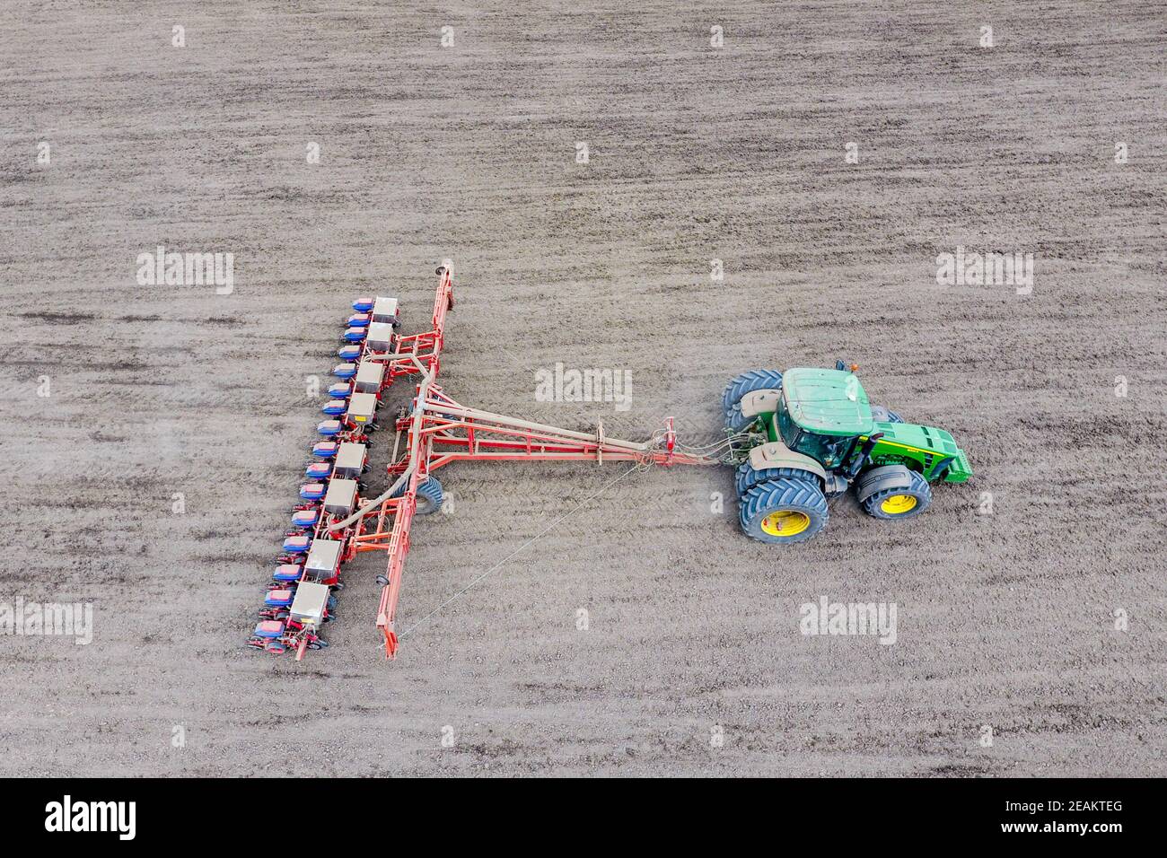 Sowing of corn. Tractor with a seeder on the field. Using a seeder for ...
