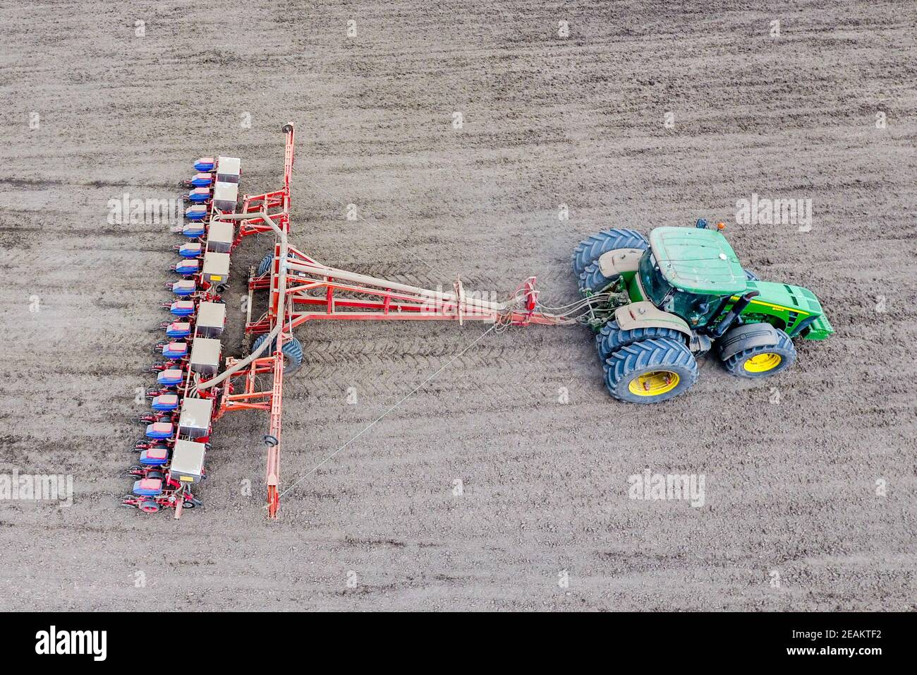 Sowing of corn. Tractor with a seeder on the field. Using a seeder for ...