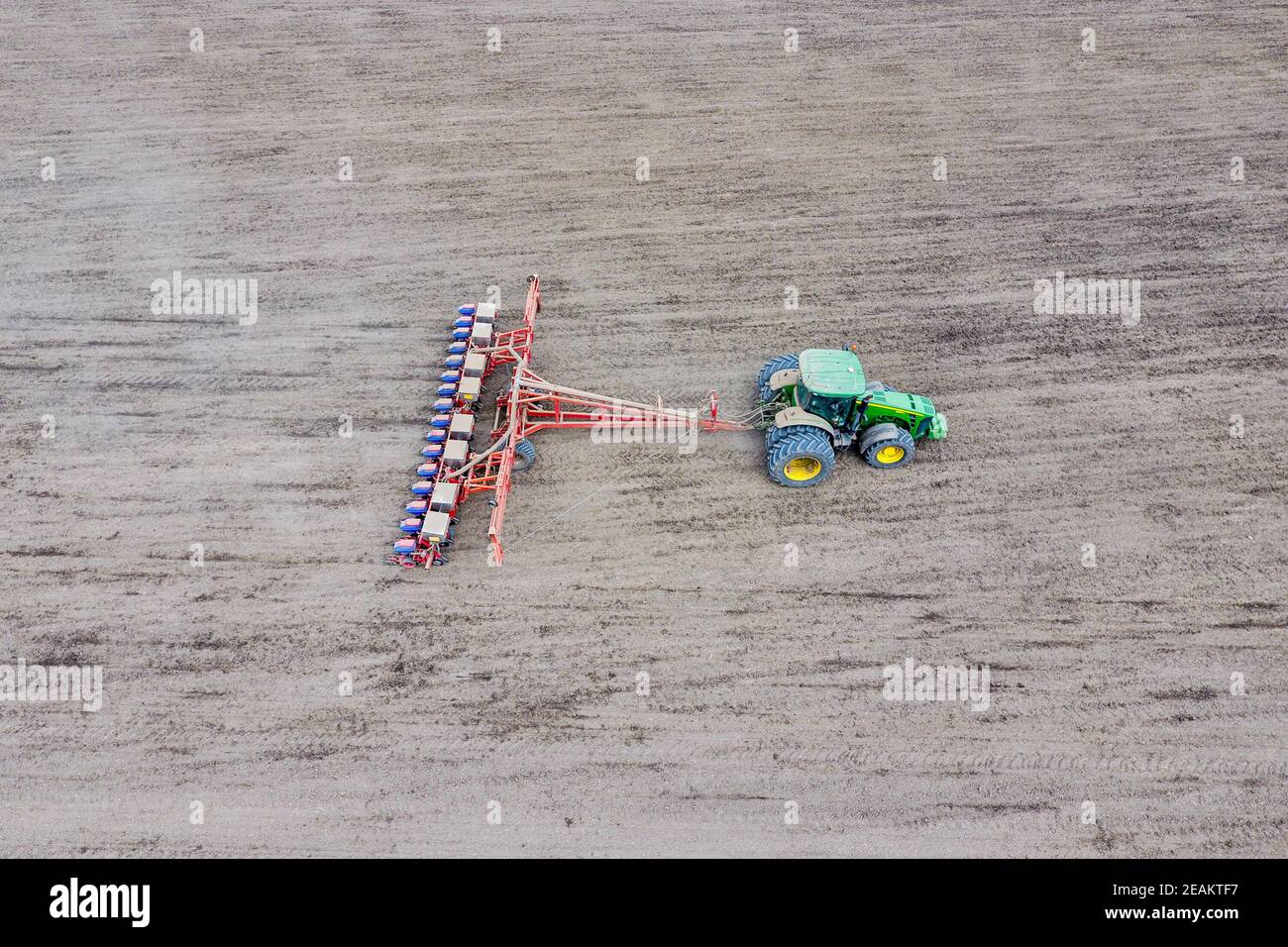 Sowing of corn. Tractor with a seeder on the field. Using a seeder for ...