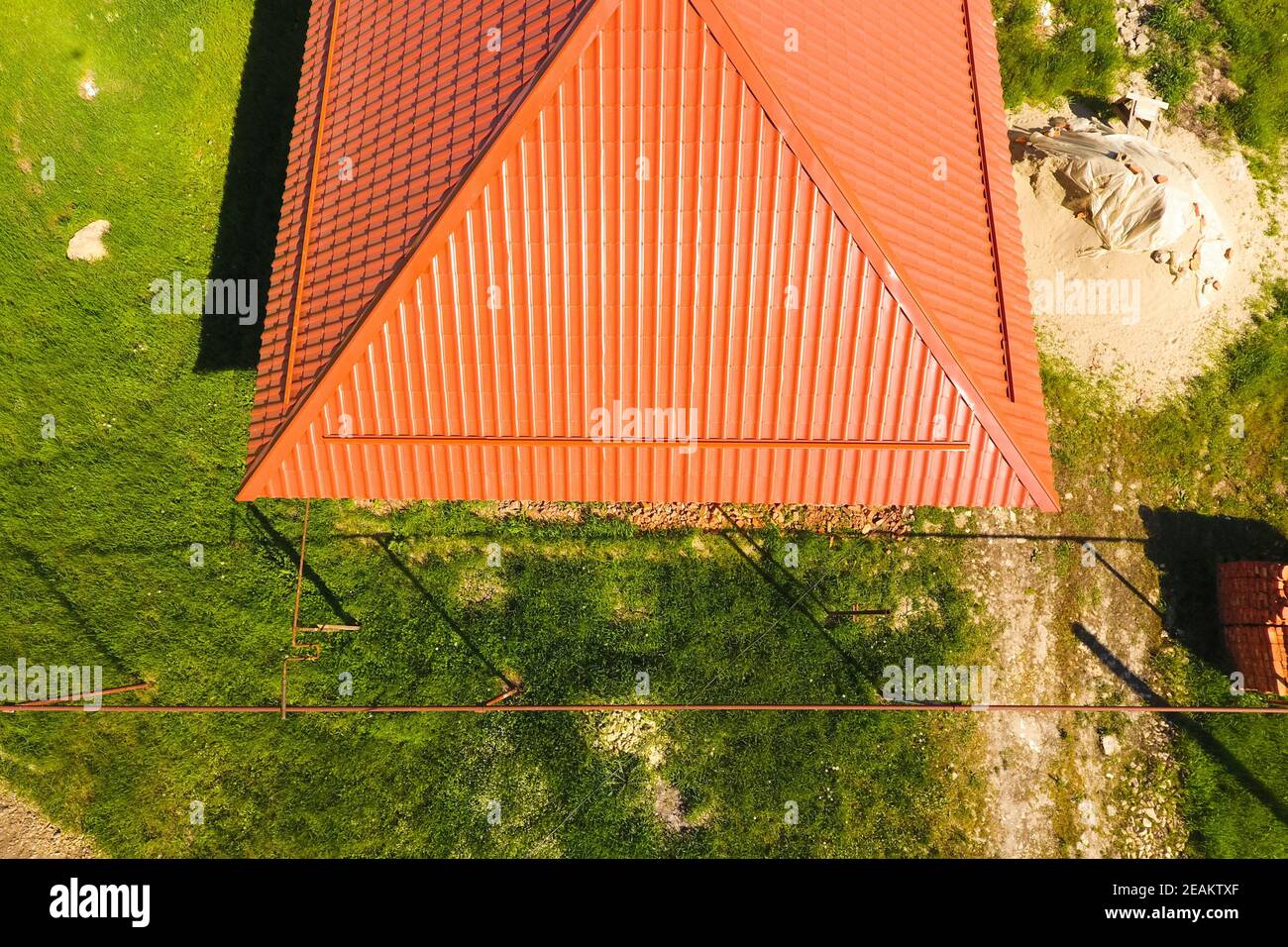 House with an orange roof made of metal, top view. Metallic profile ...