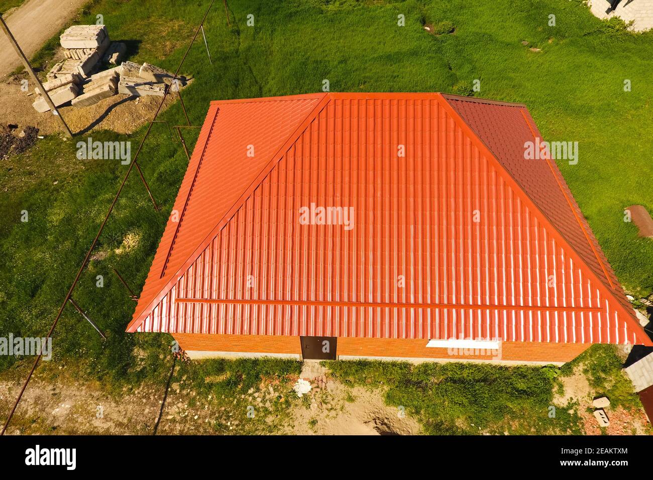 House with an orange roof made of metal, top view. Metallic profile ...