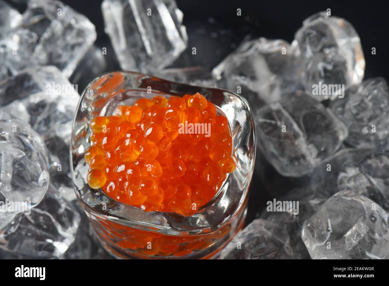 Red Caviar in a spoon on ice background. Close-up salmon caviar ...