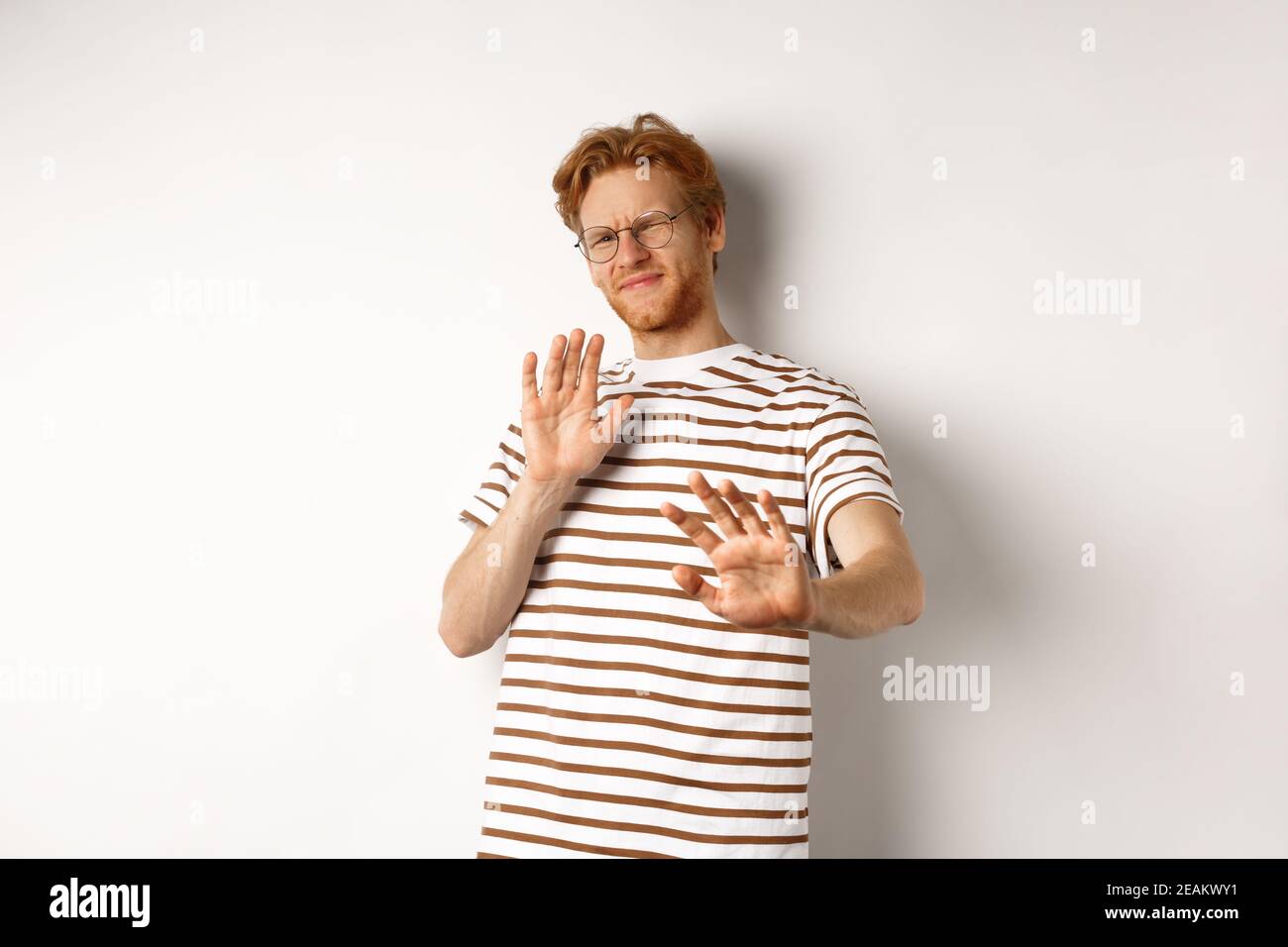 Displeased young man with red hair and bristle showing stop gesture ...