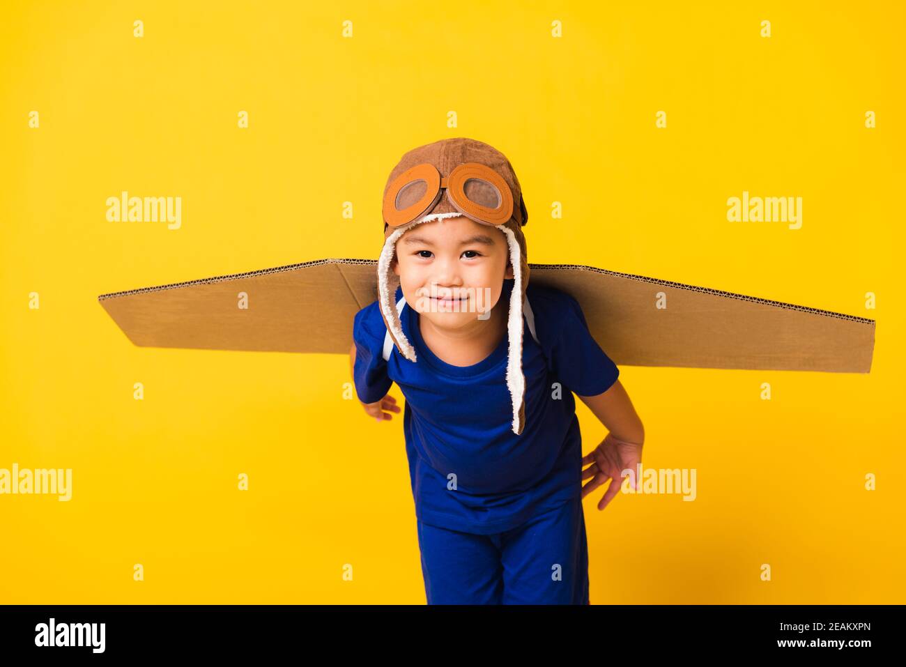 Kid little boy smile wear pilot hat play and goggles with toy cardboard ...