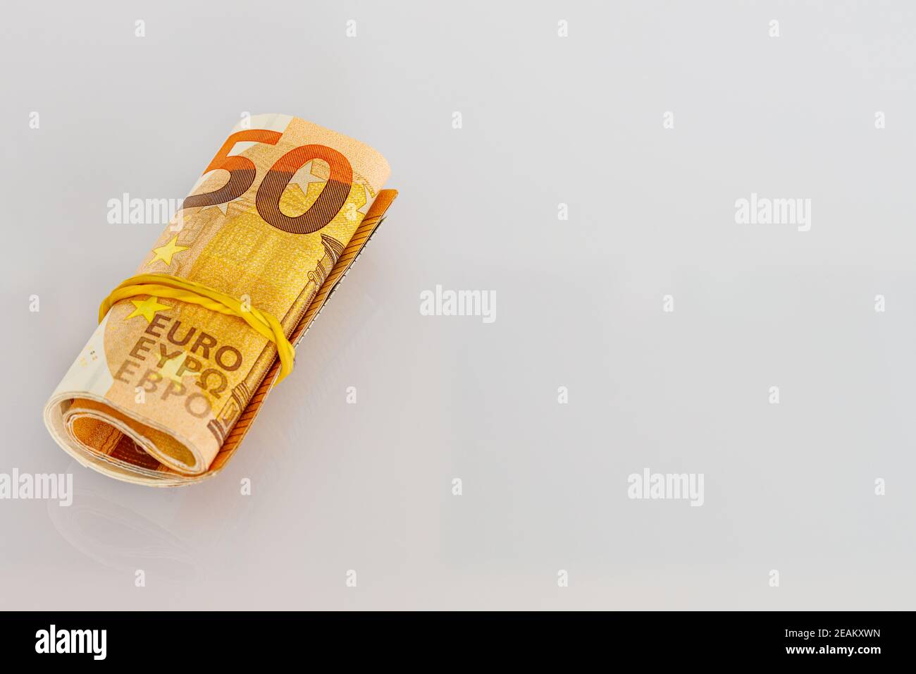 Rolled cash money on a withe background Stock Photo - Alamy