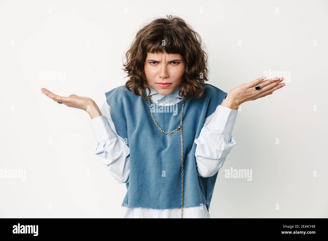 Confused beautiful girl posing and holding copyspace isolated over ...