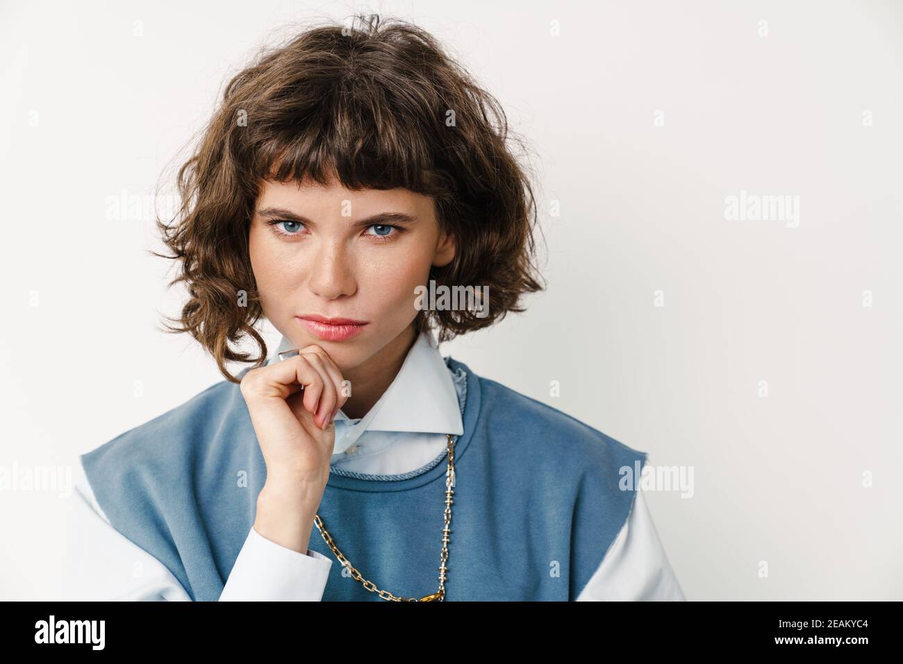 Serious beautiful girl thinking and looking at camera isolated over ...