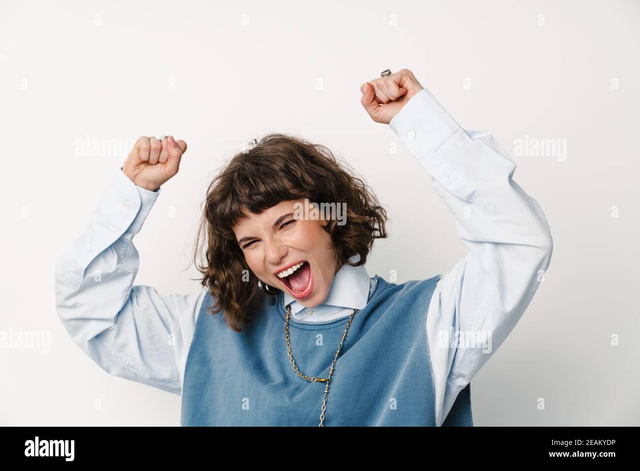 Excited beautiful girl screaming and making winner gesture isolated ...