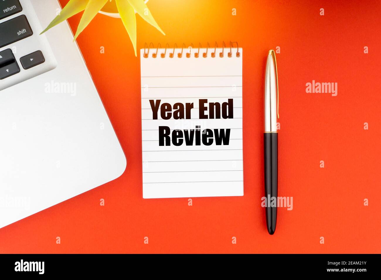 YEAR END REVIEW text with notepad, laptop, fountain pen and decorative ...