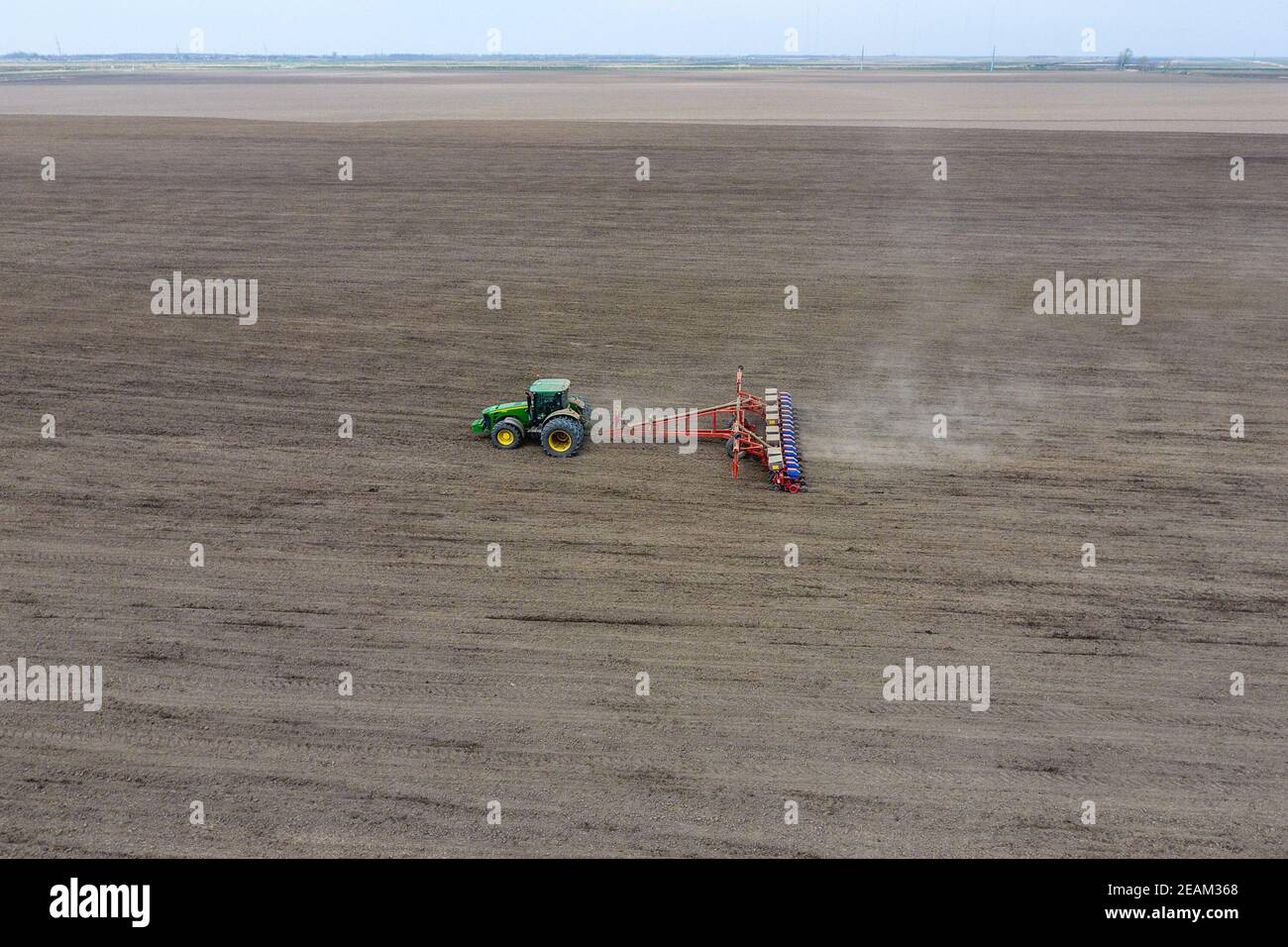 Sowing of corn. Tractor with a seeder on the field. Using a seeder for ...