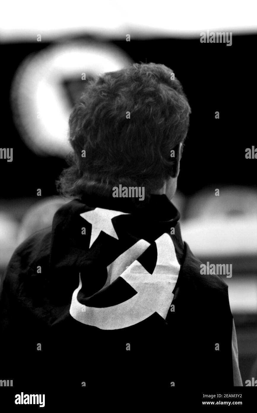 Vertical grayscale shot of a protester with a Soviet Union flag on his ...