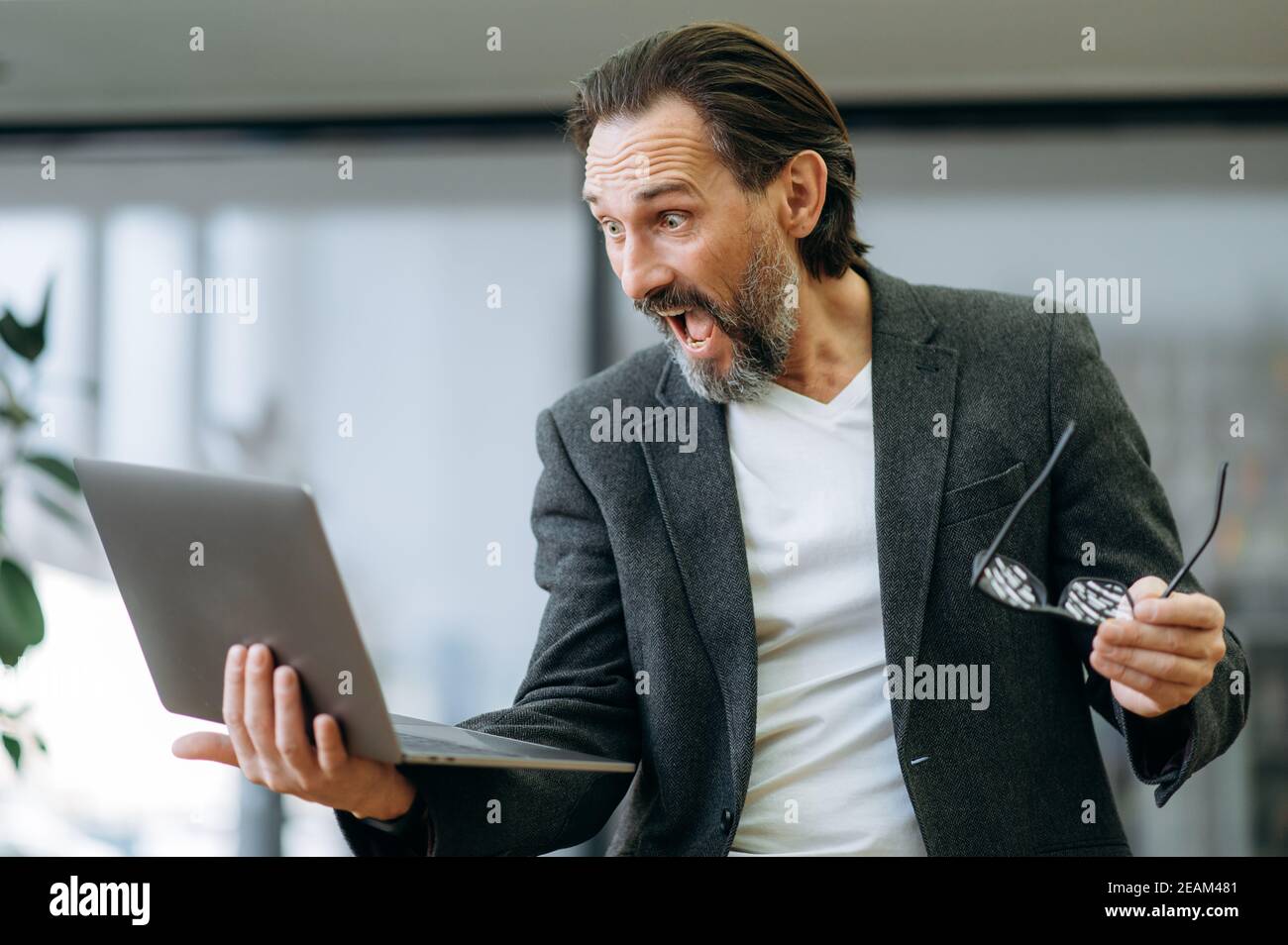 Shocked Mature Overjoyed Businessman Wearing Formal Clothes Using
