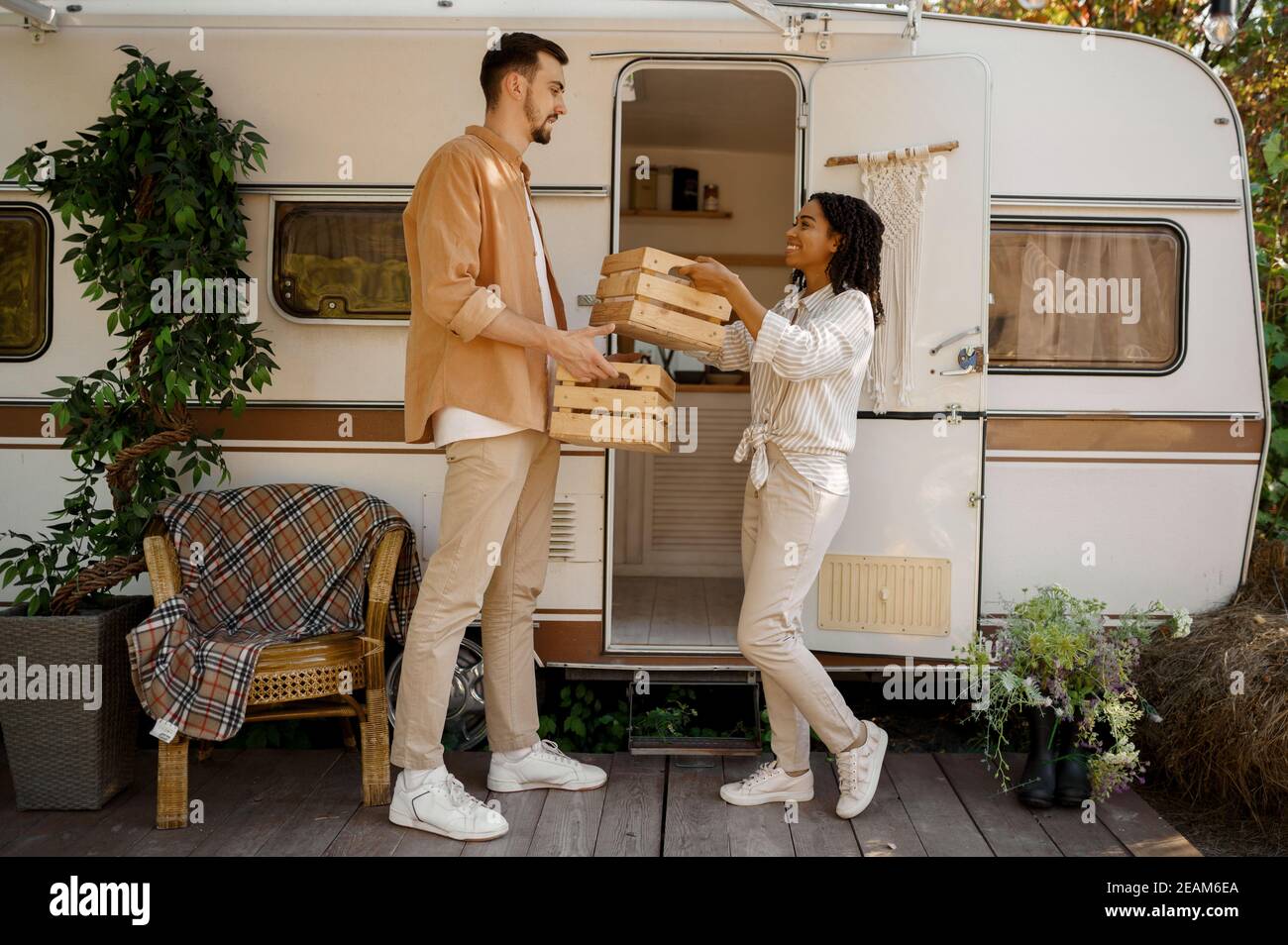 Couple holds provision near rv, camping in trailer Stock Photo - Alamy