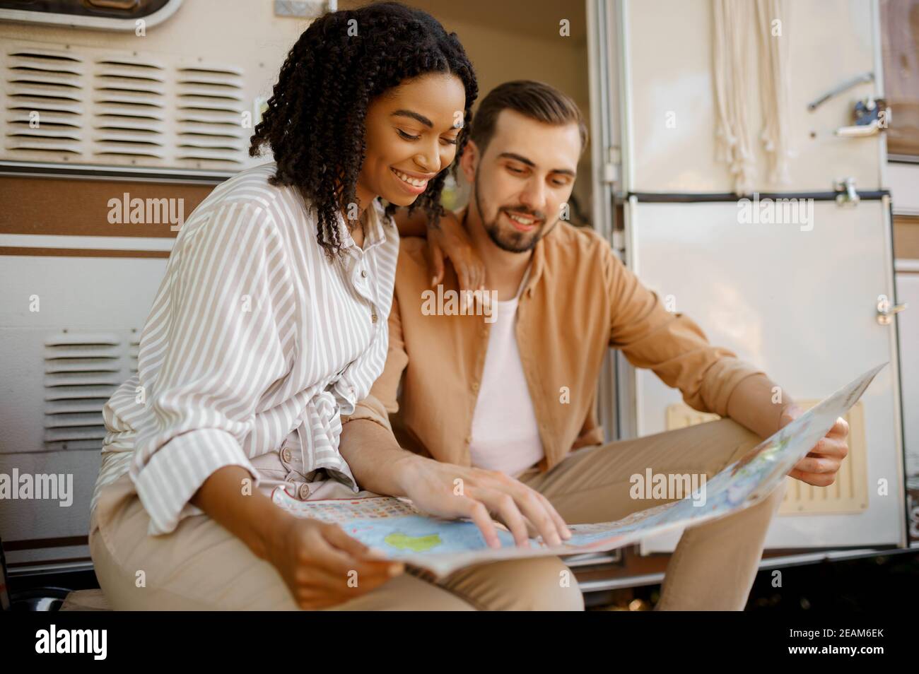 Couple looking on map near rv, camping in trailer Stock Photo - Alamy