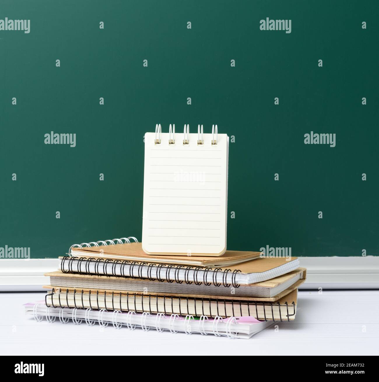 blank green chalk school board and stack of notebooks, back to school ...