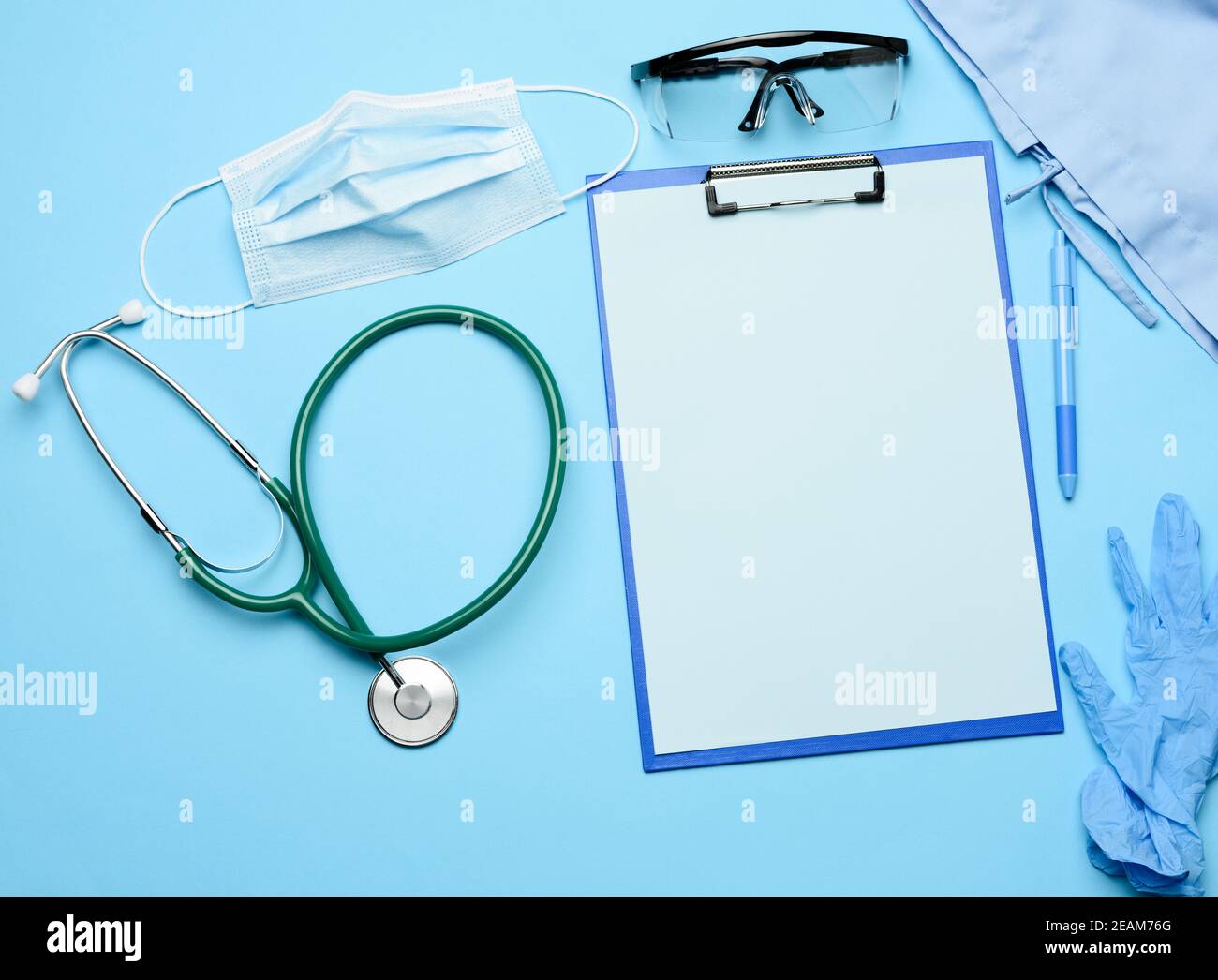 disposable medical mask, plastic goggles and stethoscope on blue ...