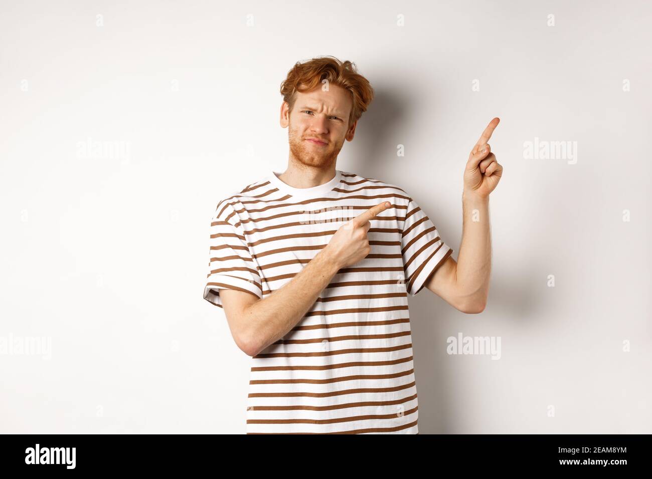 Judgemental redhead guy frowning disappointed, pointing fingers upper ...