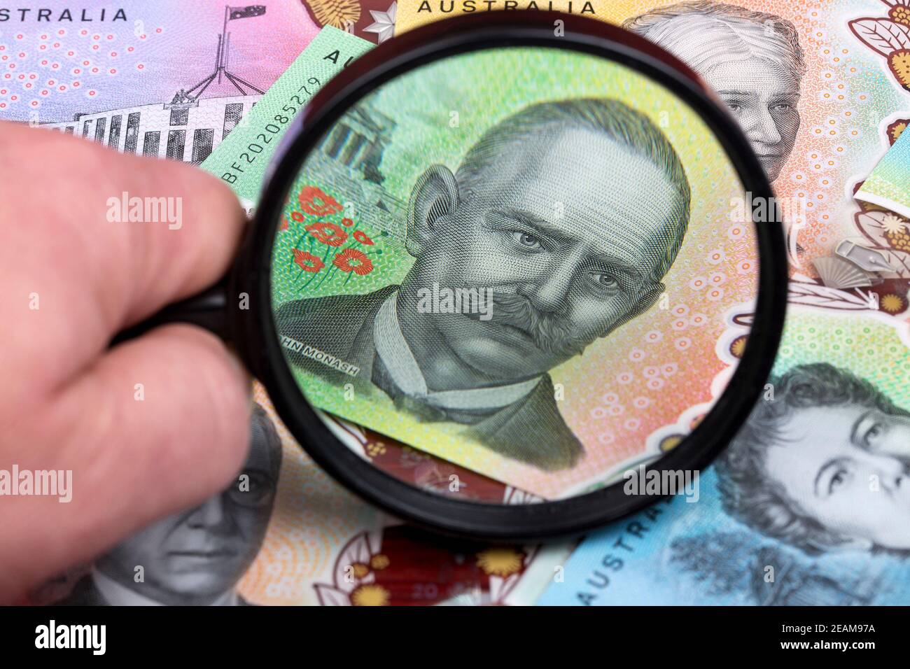 Australian dollars in a magnifying glass Stock Photo - Alamy