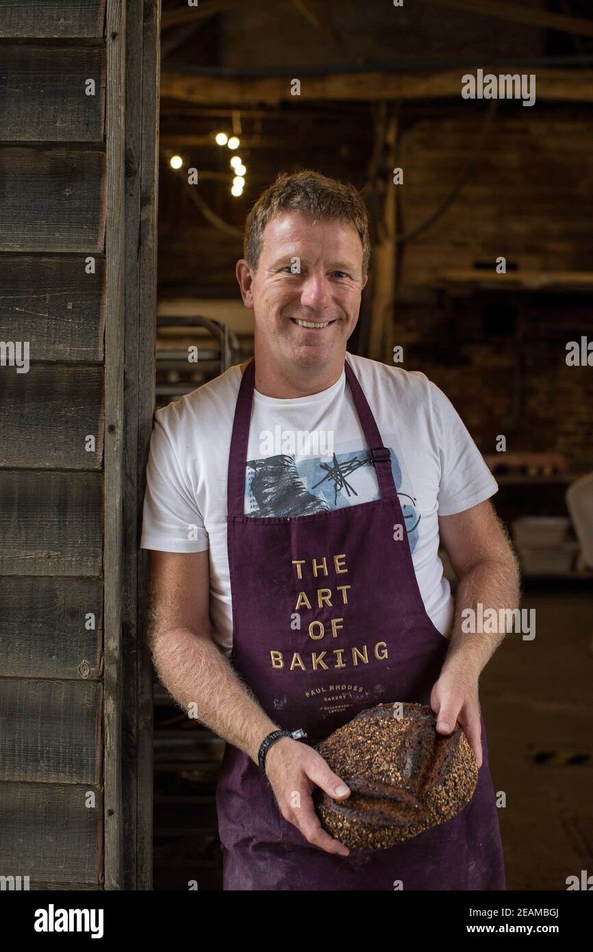 GREAT BRITAIN / England / Hertfordshire / Baker holding freshly baked ...