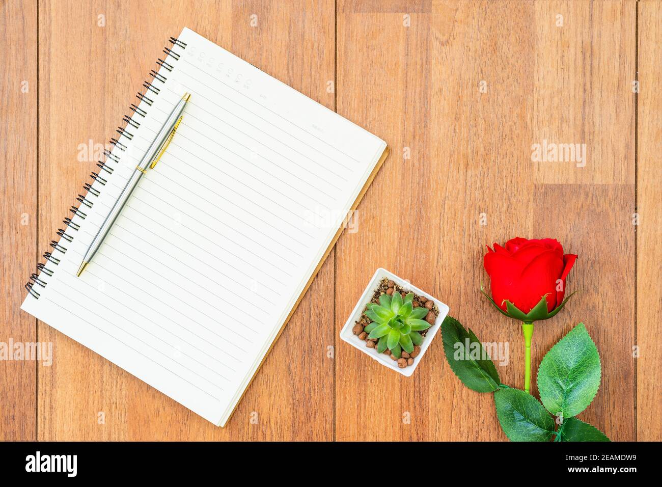 Red roses on wooden table and notepad Stock Photo - Alamy