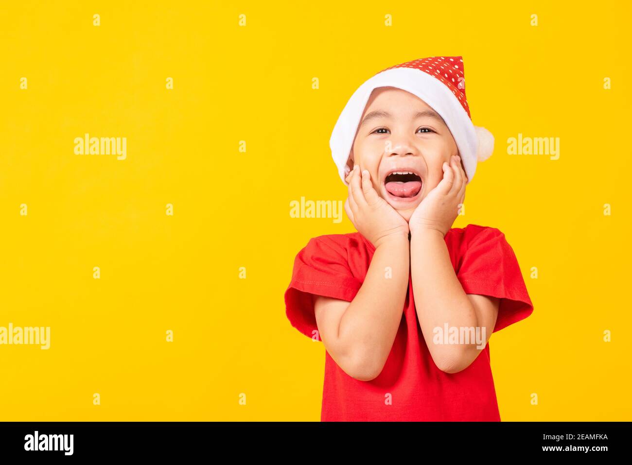 Kids dressed in red Santa Claus hat shocked and surprised hand hold ...