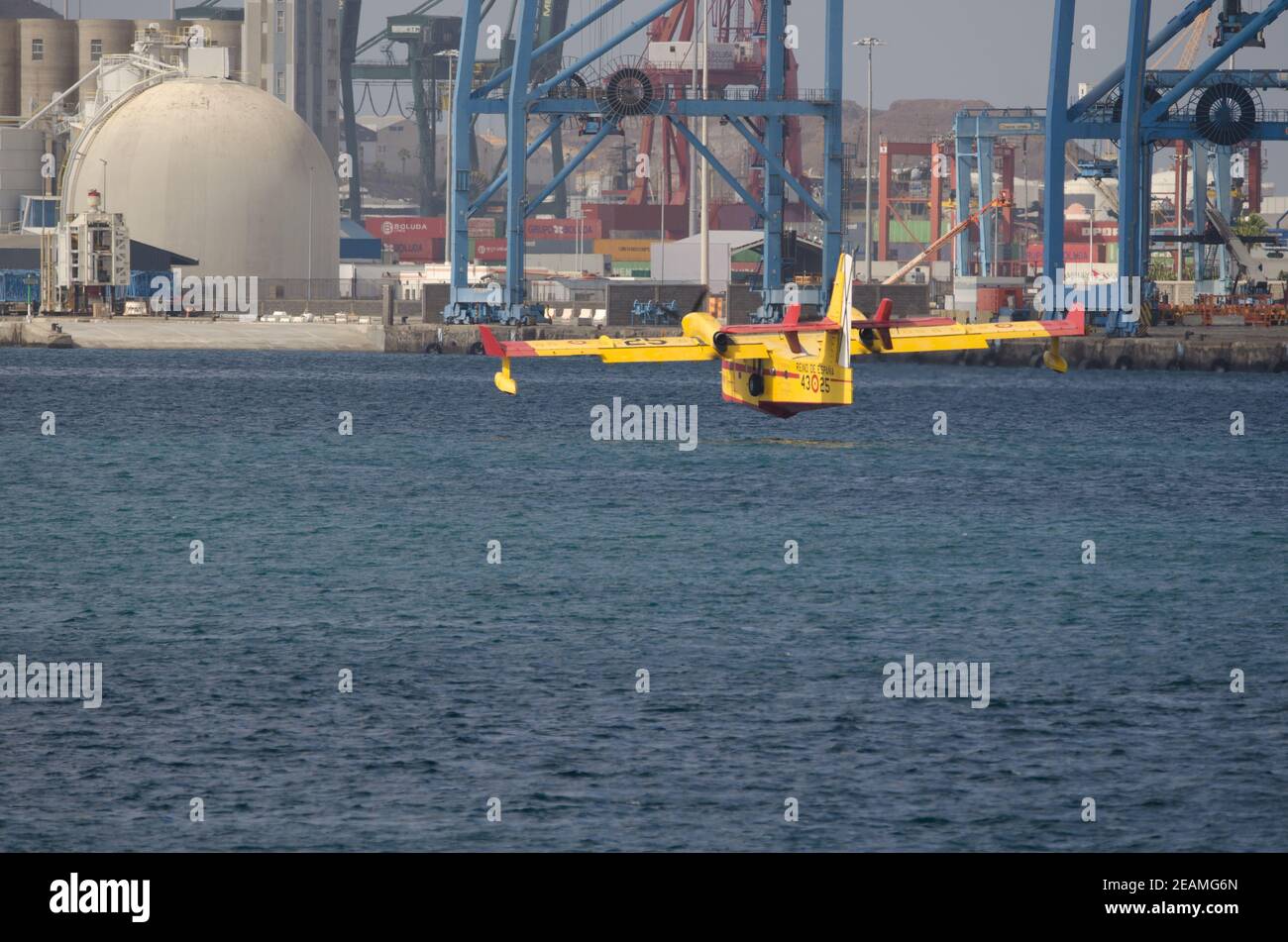 Fire-fighting plane collecting sea water to extinguish a forest fire ...