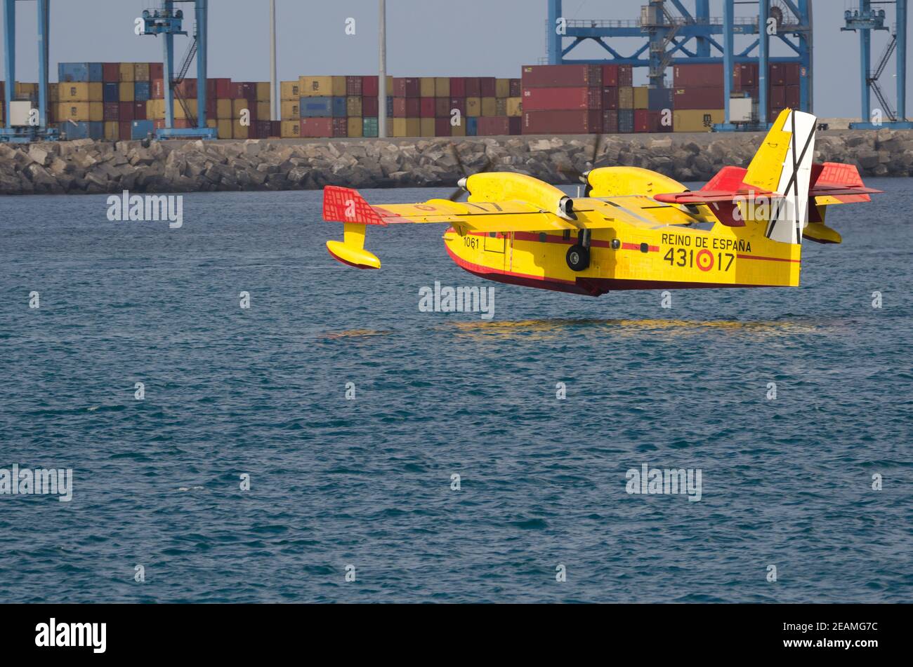 Fire-fighting plane collecting sea water to extinguish a forest fire ...